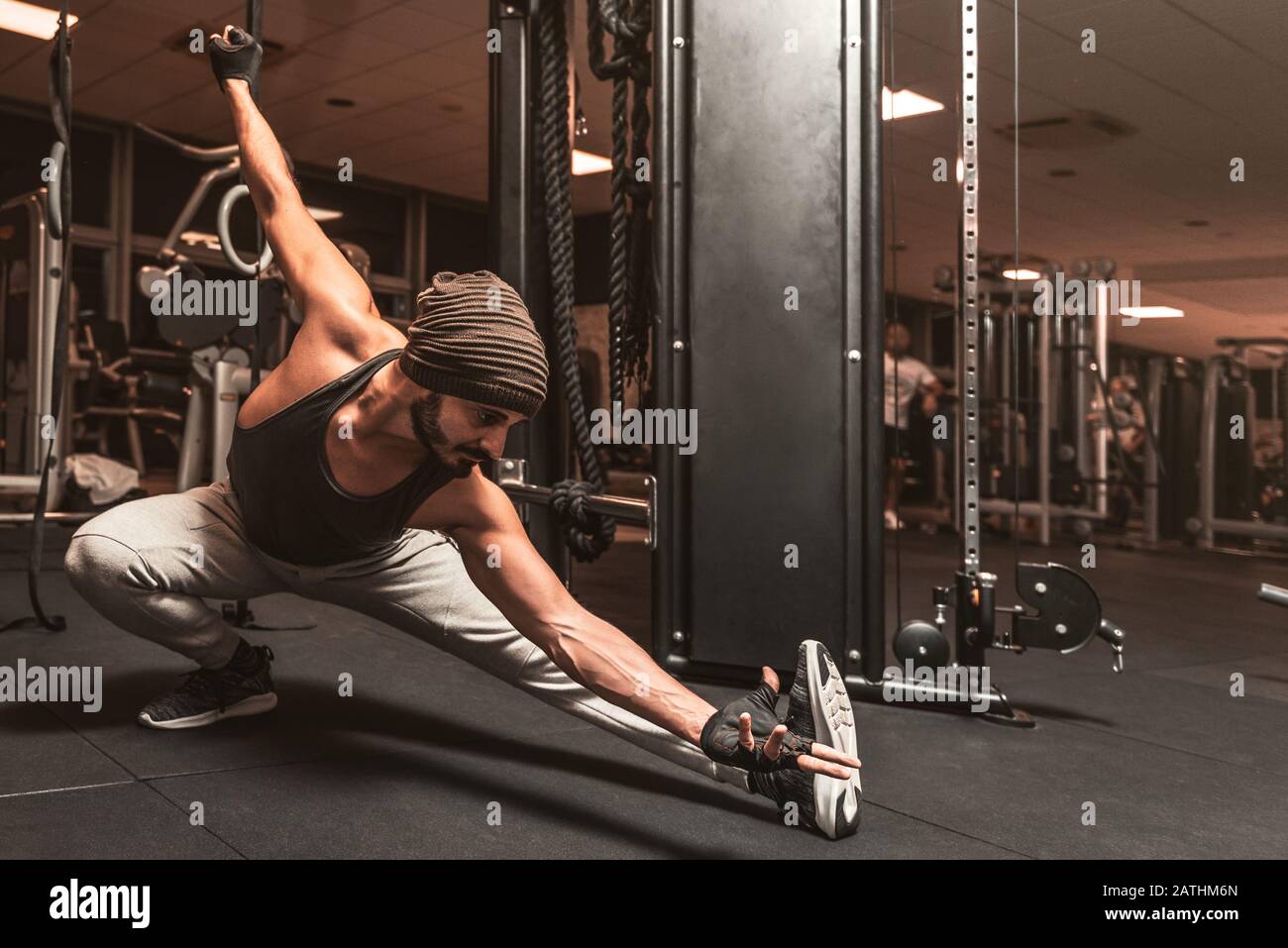A bearded sporty man in the gym is doing Yoga and Martial Arts ...