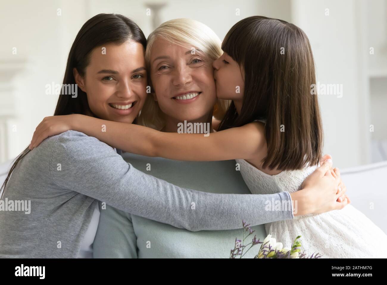 Portrait of smiling three generations of women cuddling together Stock ...