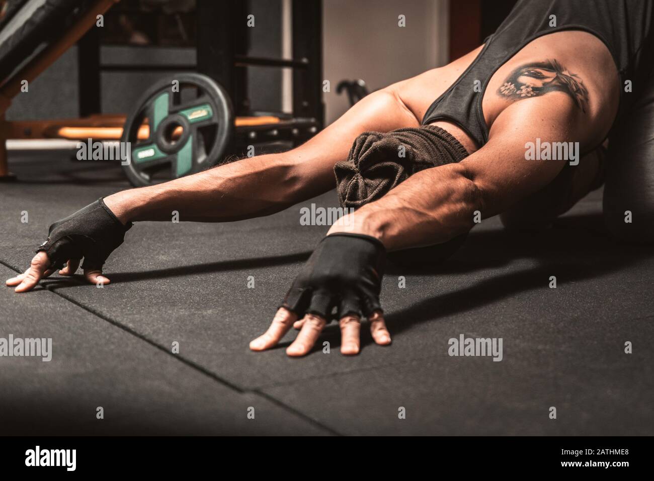 A sporty man in the gym is doing Yoga exercises. Back stretch exercise ...