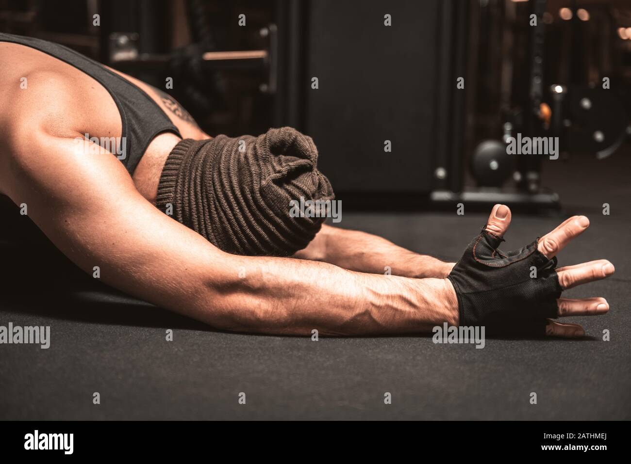 A sporty man in the gym is doing Yoga exercises. Back stretch exercise ...