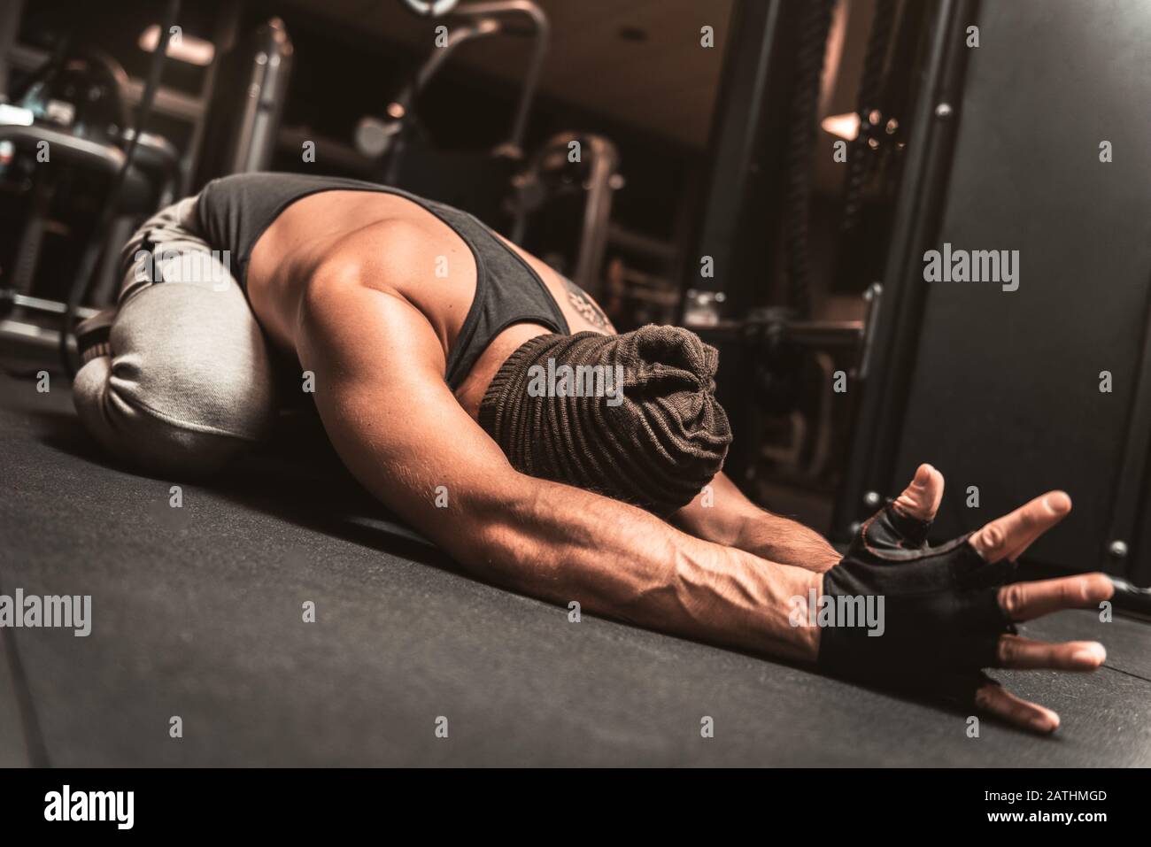 A sporty man in the gym is doing Yoga exercises. Back stretch exercise ...