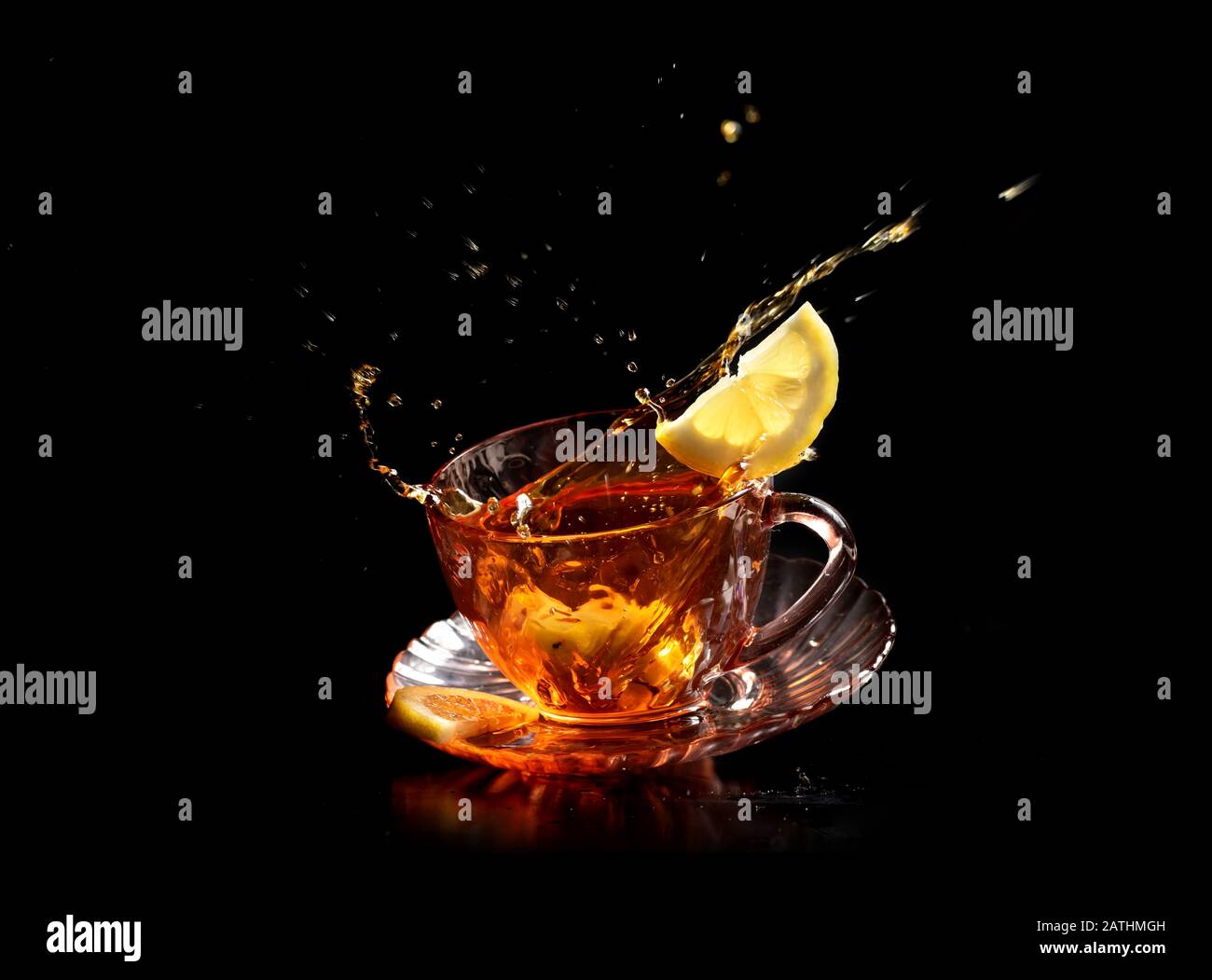 Lemon flies out of a tea mug on a black background with lots of ...