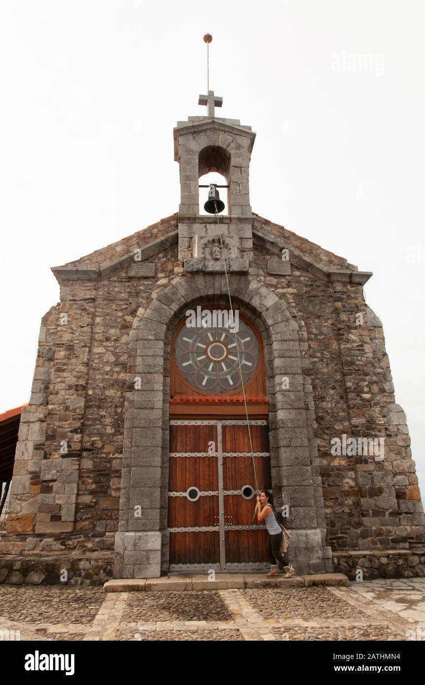 Tourist pull the rope of the church bell on the san juan de ...