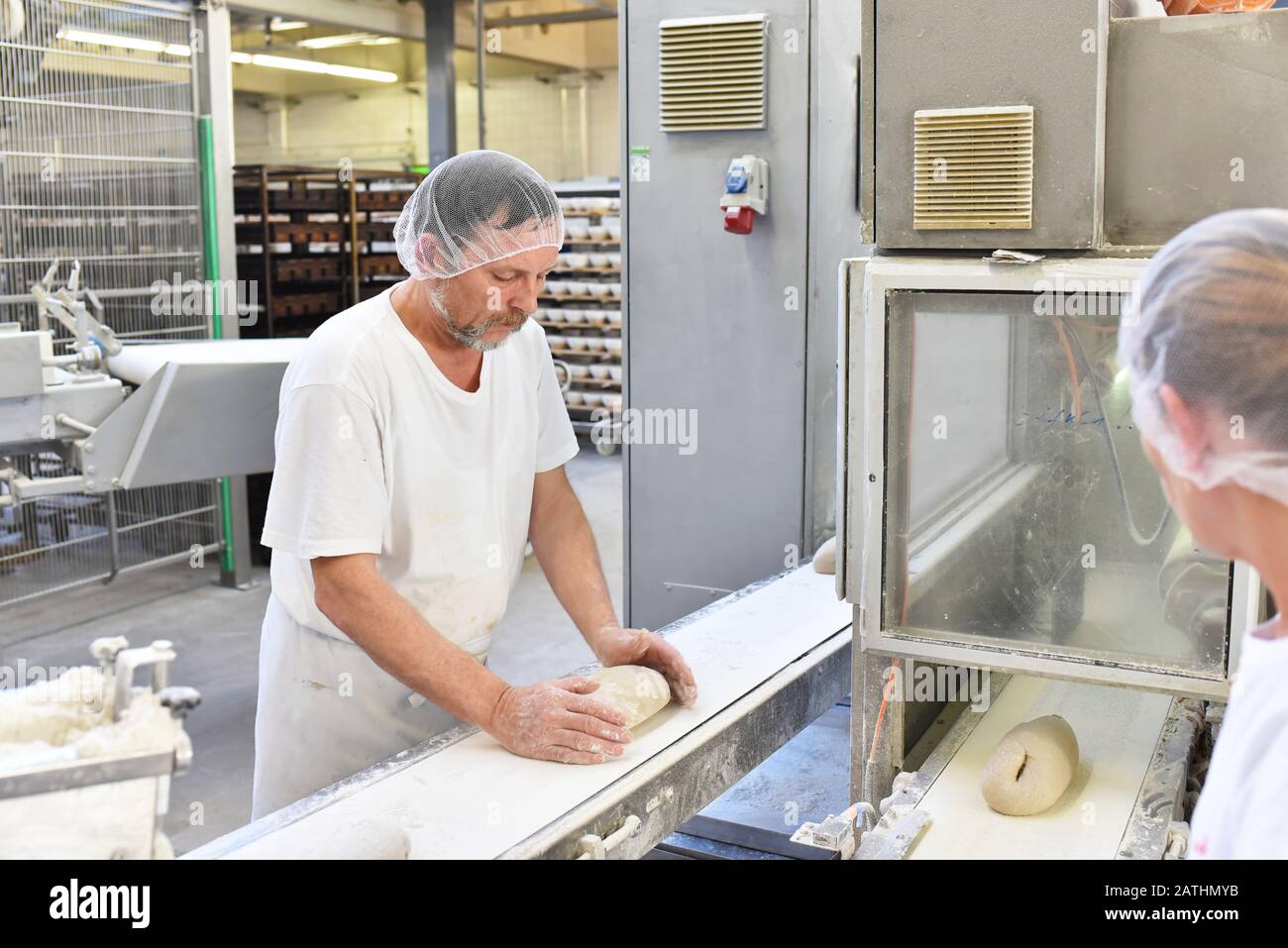 Worker in a large bakery - industrial production of bakery products on ...