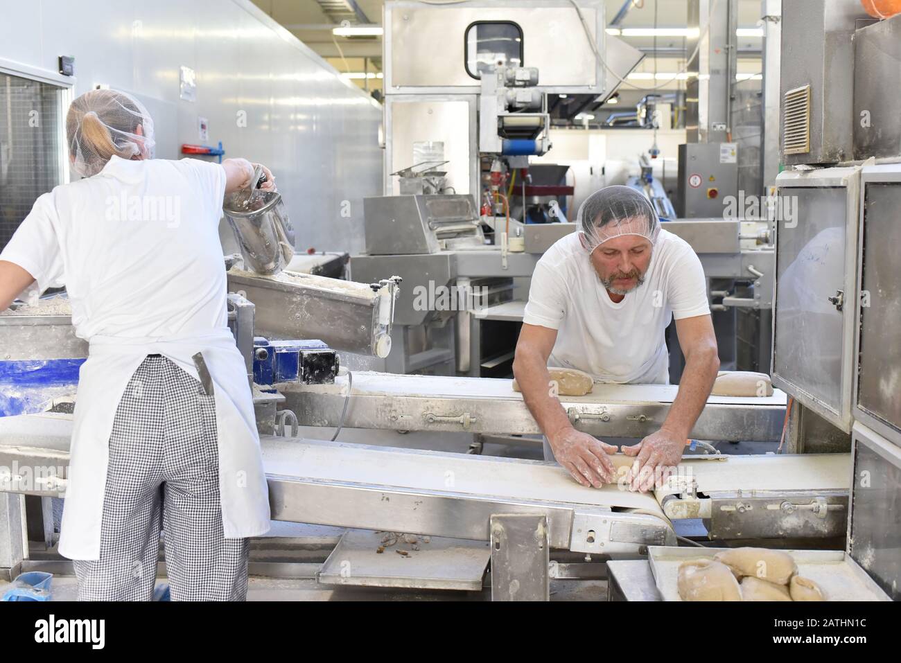 Worker in a large bakery - industrial production of bakery products on ...