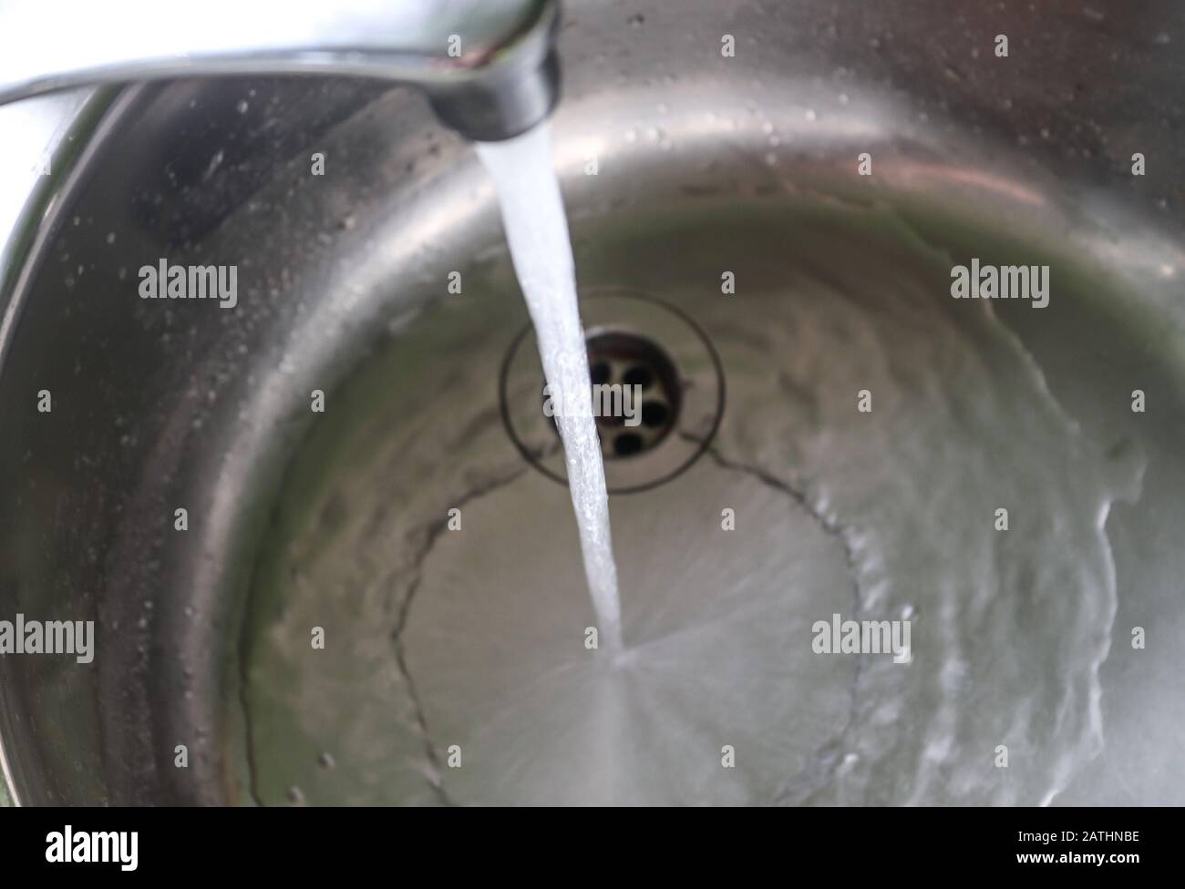 Running water out of a water tap in a metallic kitchen sink Stock Photo ...