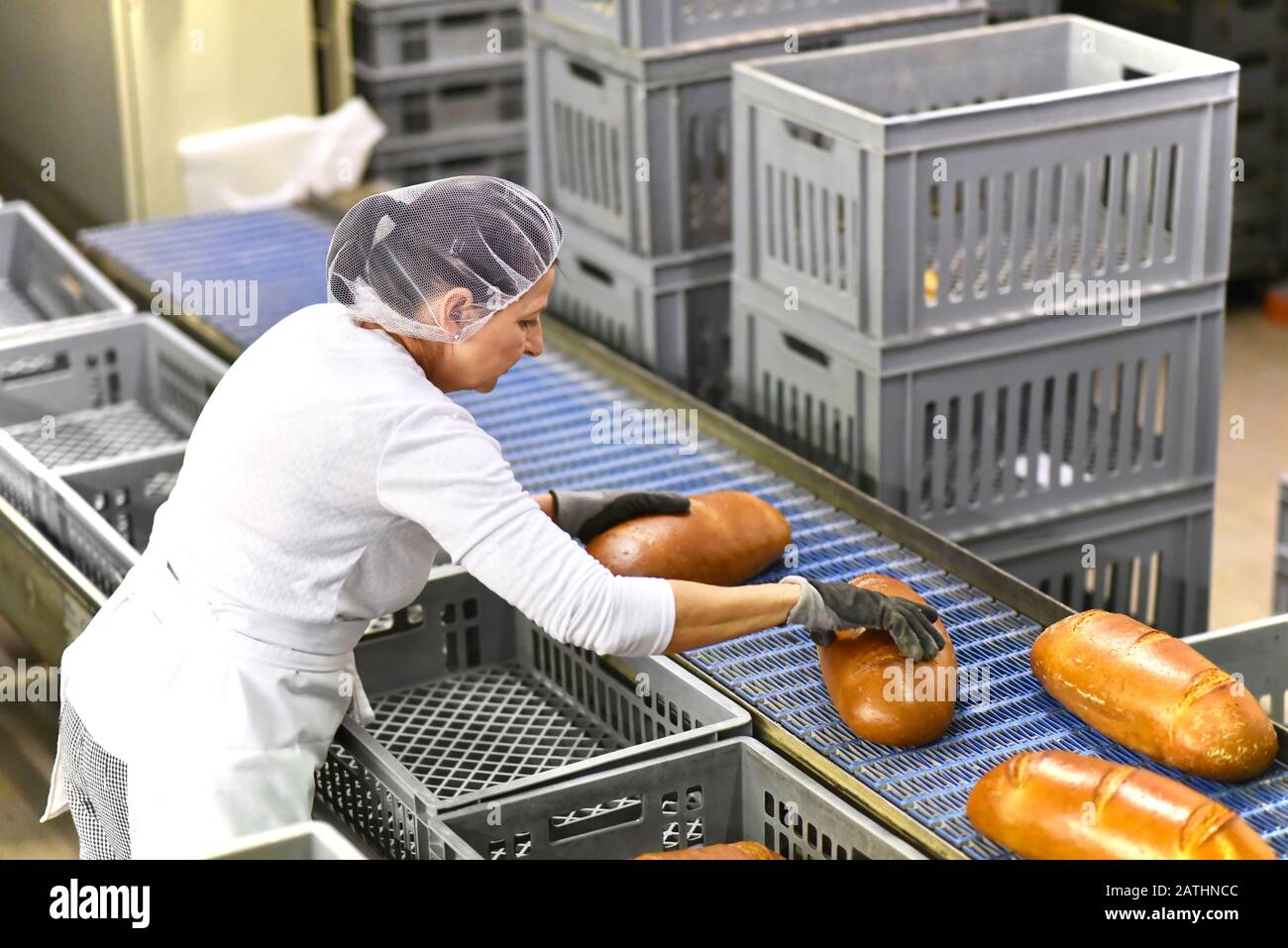 woman working in a large bakery - industrial production of bakery ...