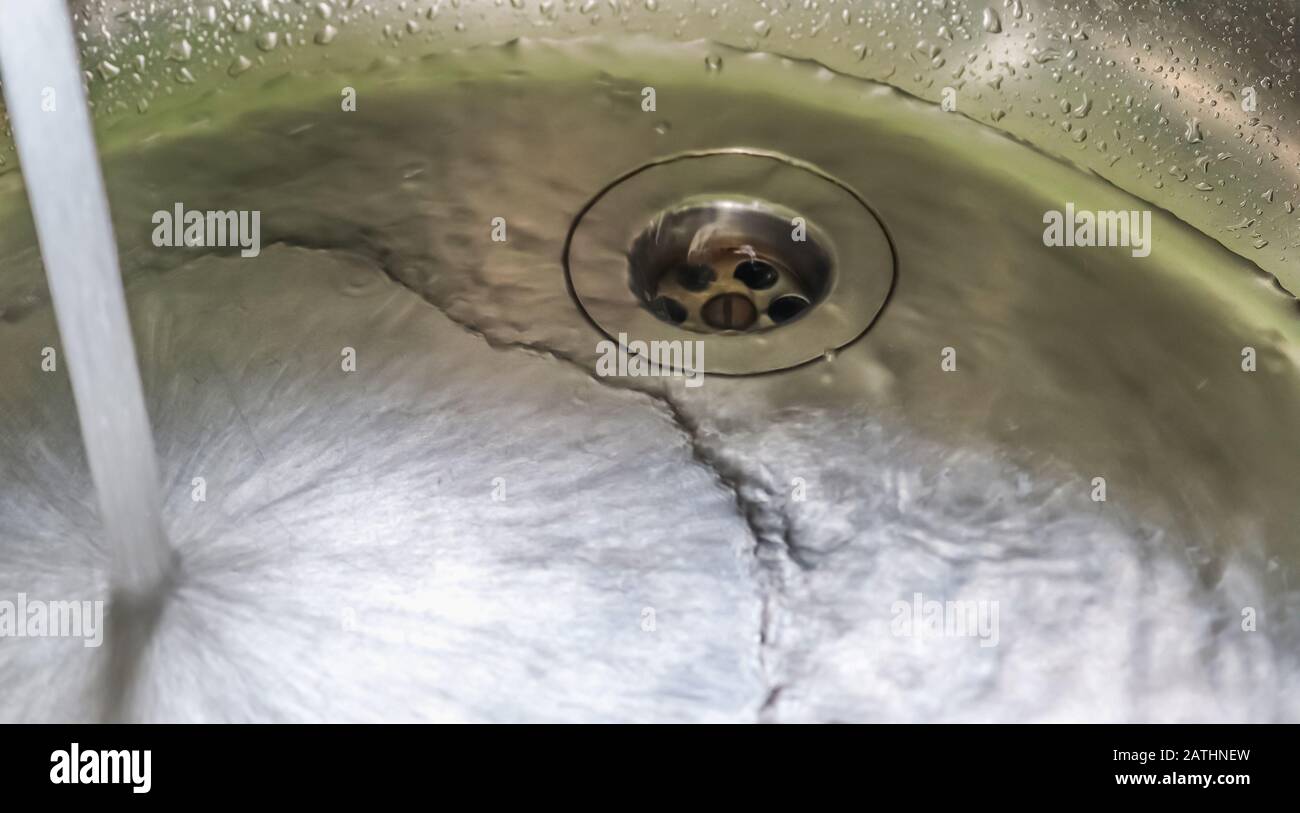 Running water out of a water tap in a metallic kitchen sink Stock Photo ...