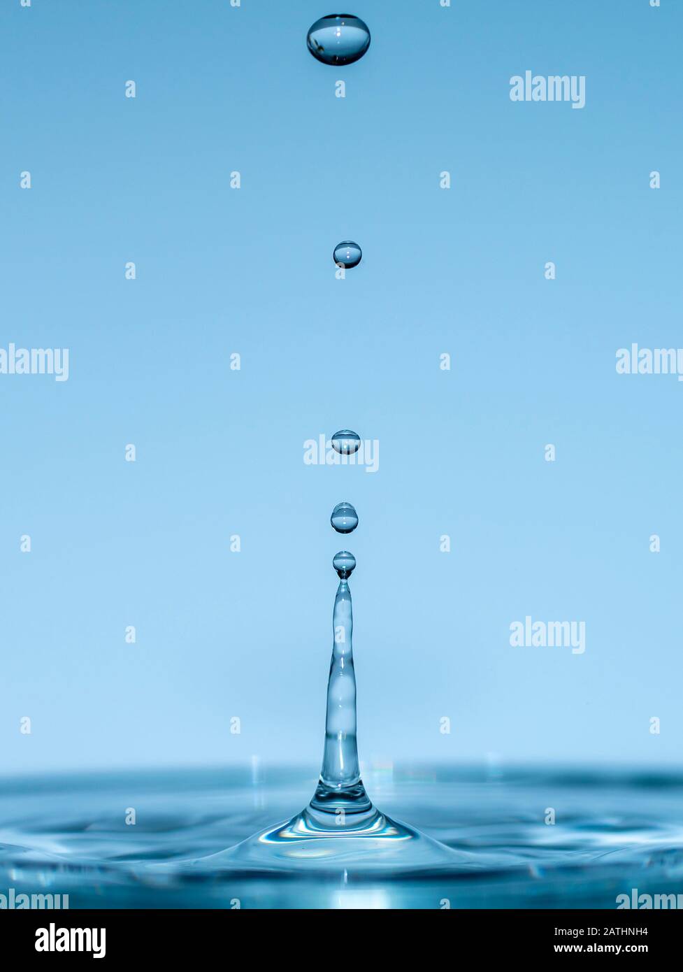 Water drops form ripples when falling into light blue clear water ...