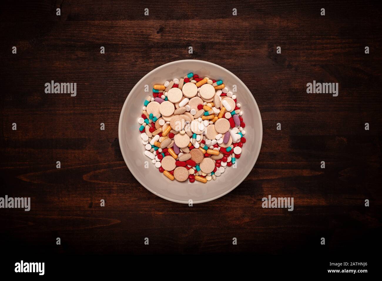 Plate full of tablets, pills and capsule medication - top view flat lay ...