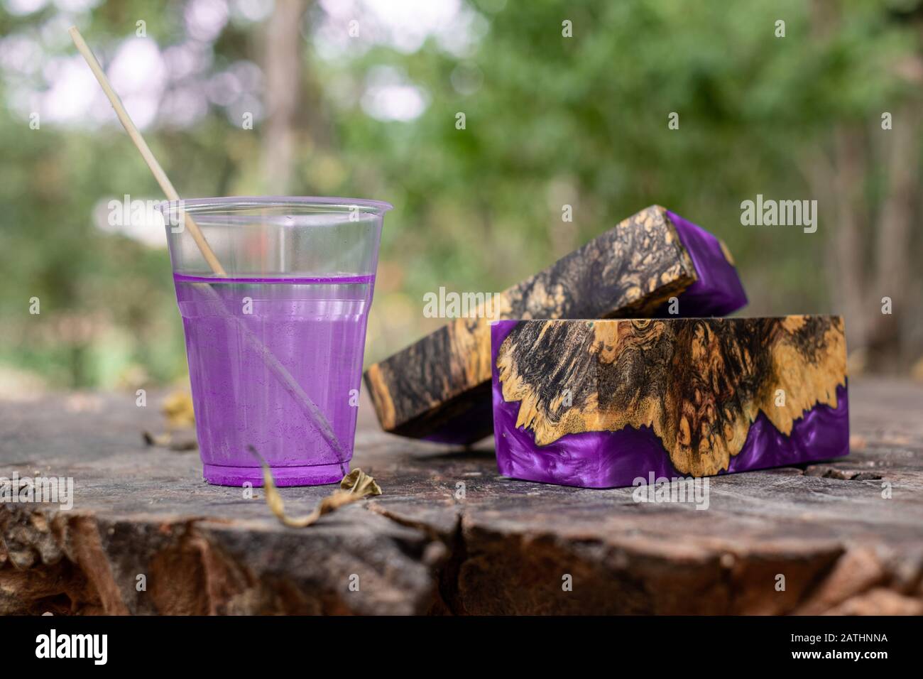 Casting purple epoxy resin burl wood cube on old table art background ...