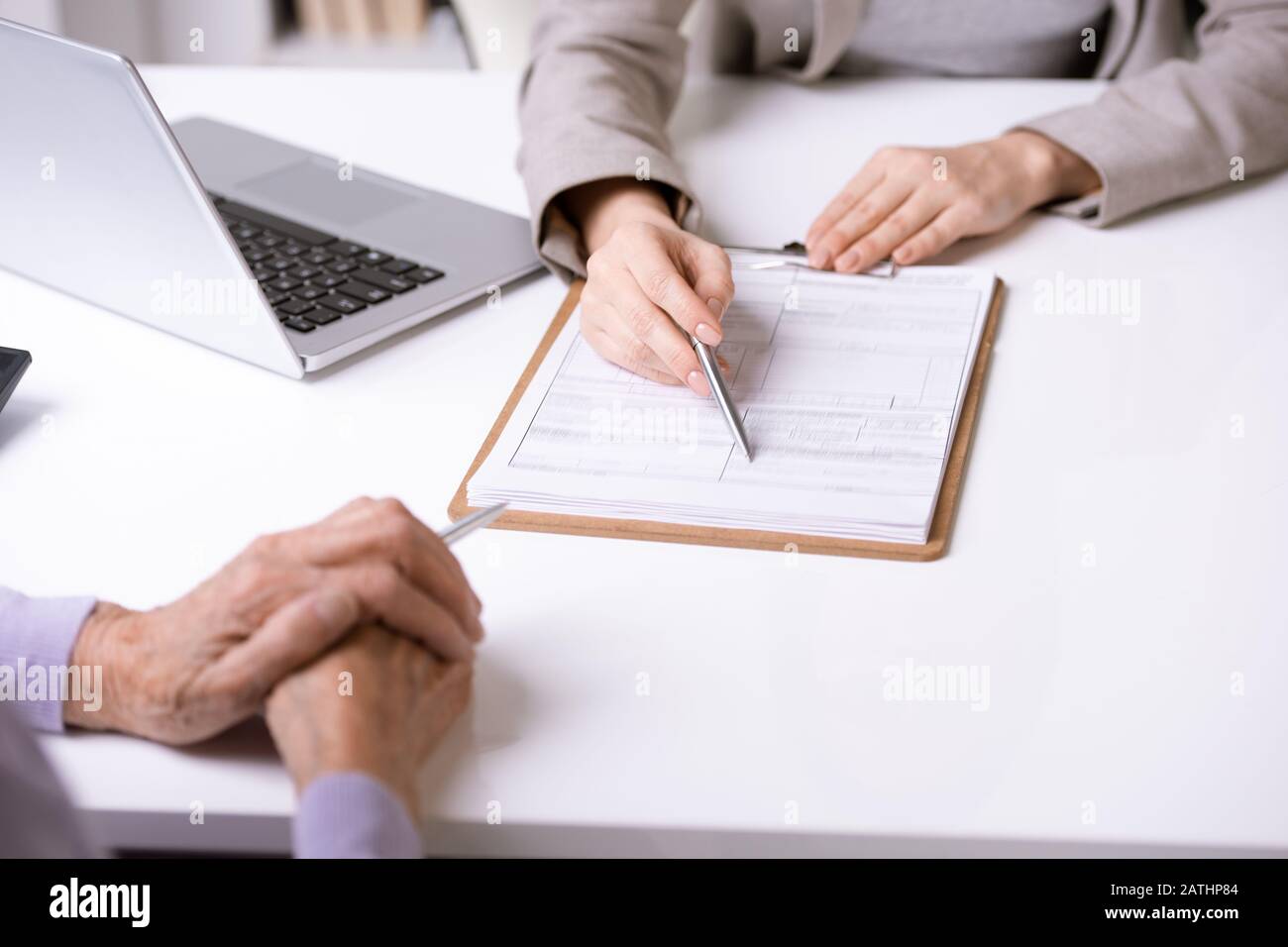 Close-up of unrecognizable advisor sitting at desk with laptop and ...