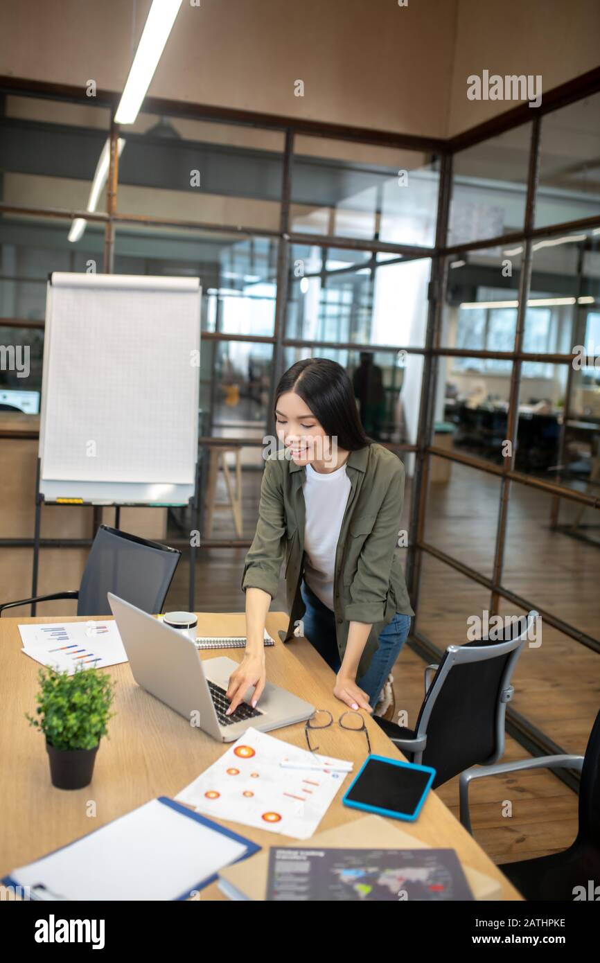 Long-haired brunette asian girl working in the office alone Stock Photo ...