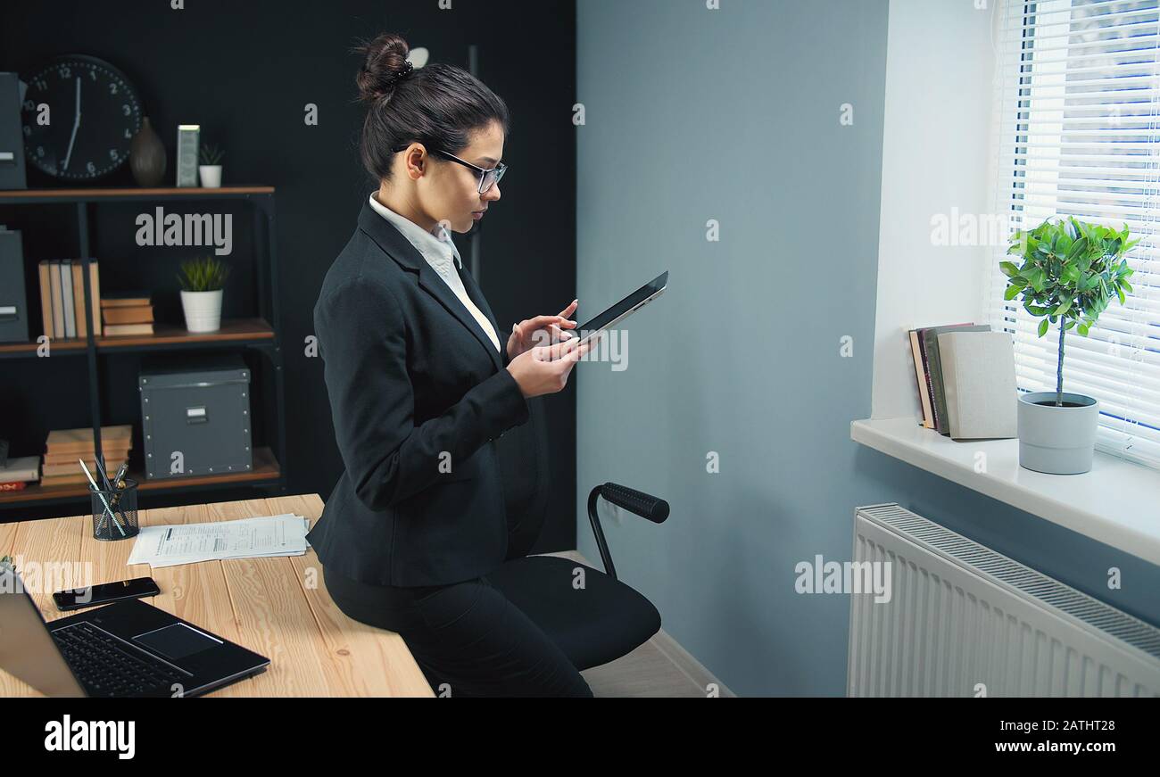 Business-looking woman using pad Stock Photo - Alamy