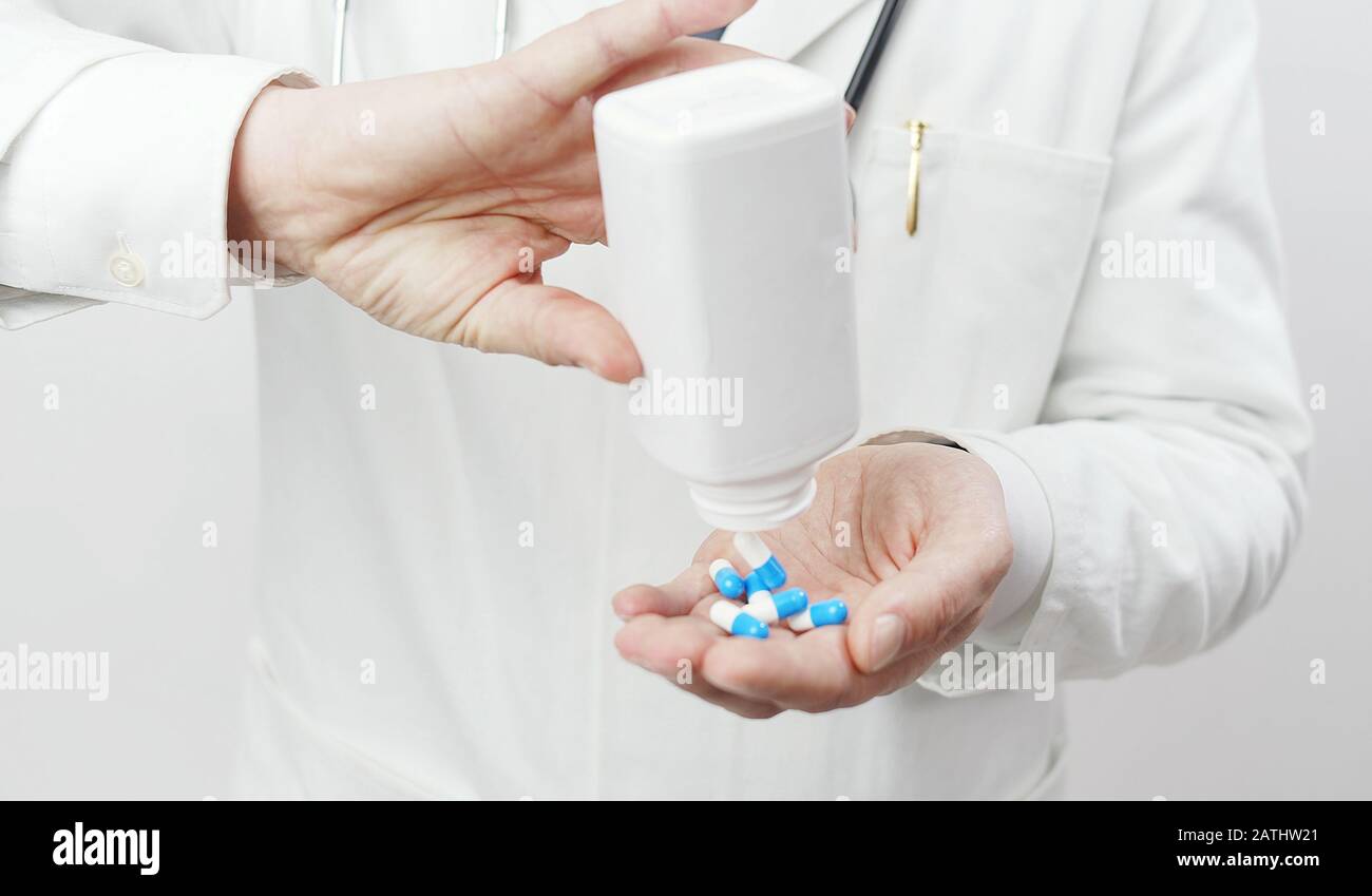 Doctor's hands dumping pills out Stock Photo - Alamy