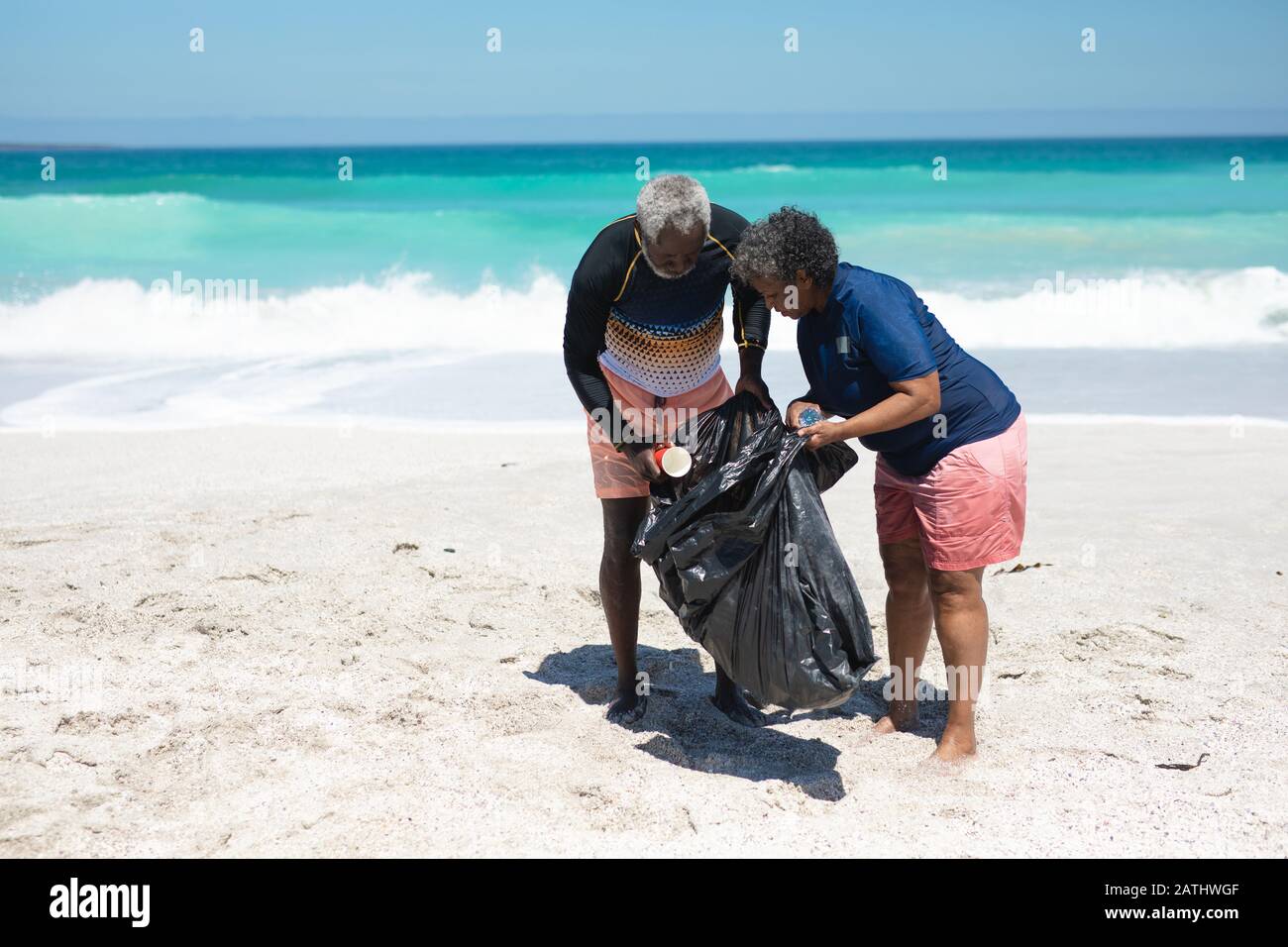 Old couple collecting waste at the beach Stock Photo - Alamy