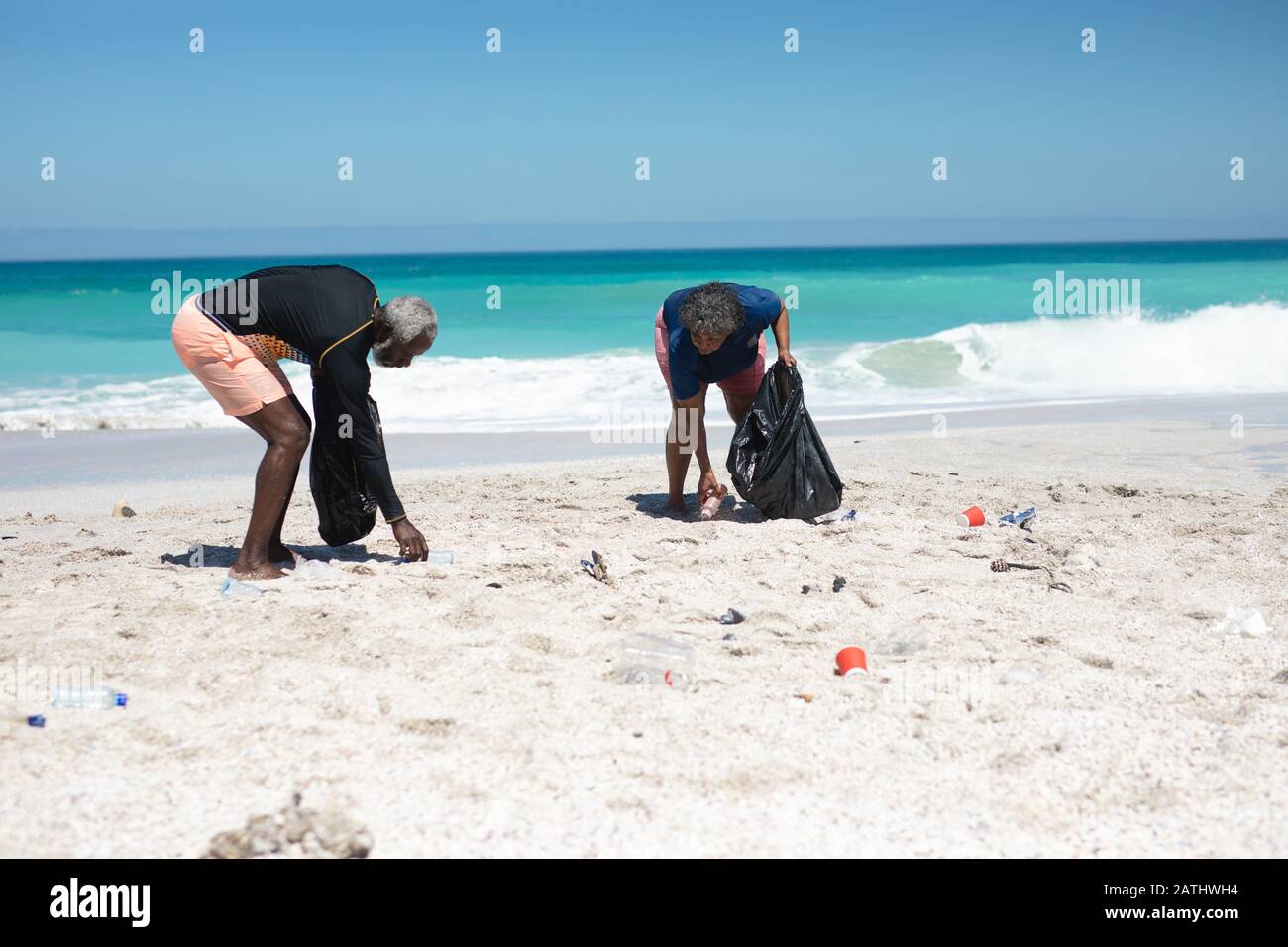 Old couple collecting waste at the beach Stock Photo - Alamy