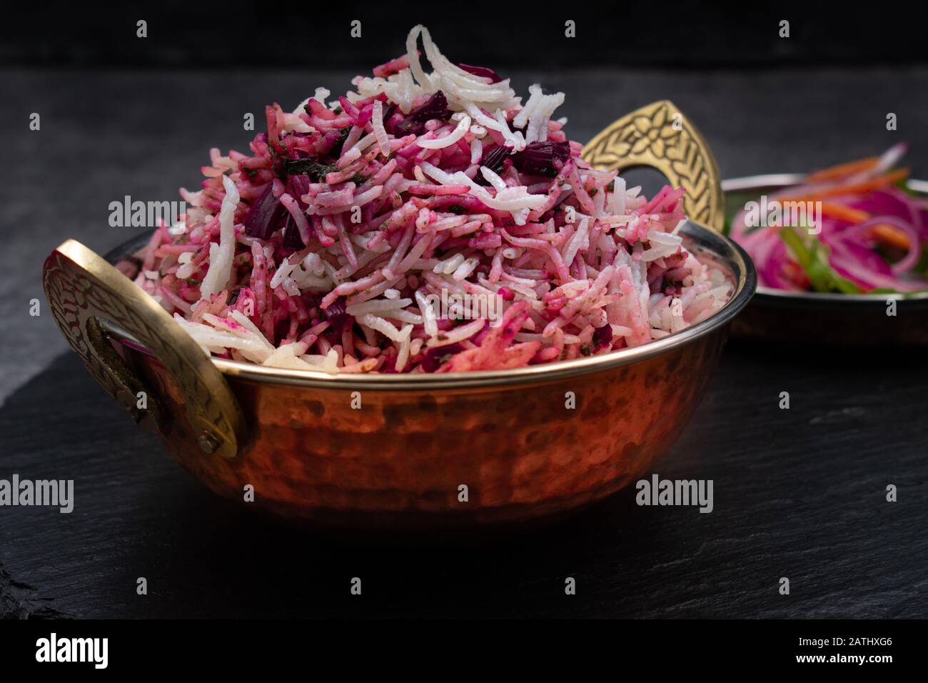 Delicious beet rice pilaf served in traditional Indian copper bowl ...