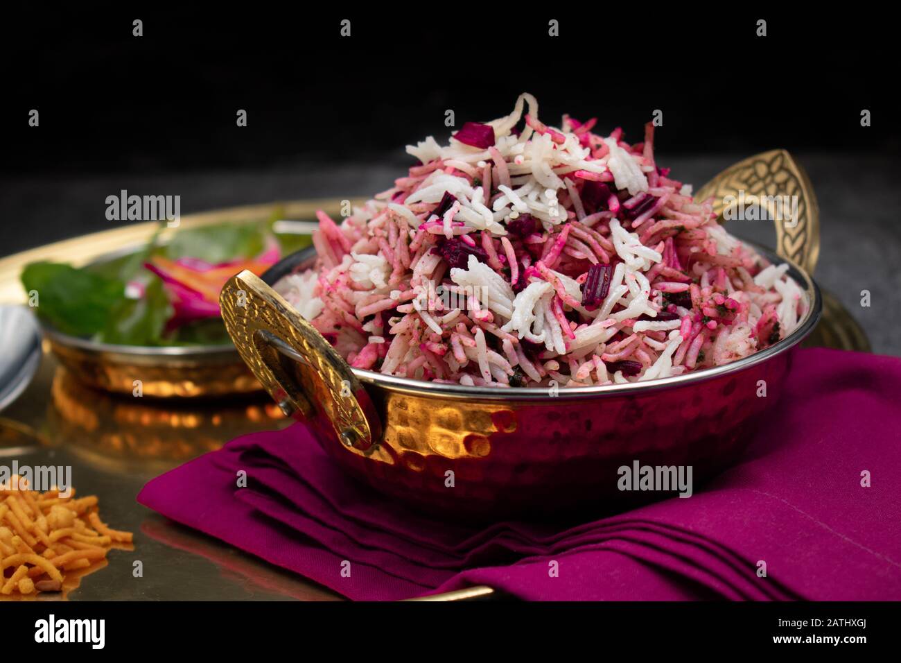 Delicious beet rice pilaf served in traditional Indian copper bowl ...