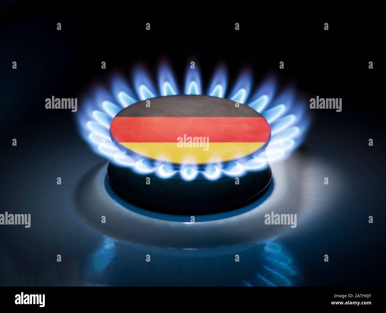 Burning gas burner of a home stove in the middle of which is the flag ...