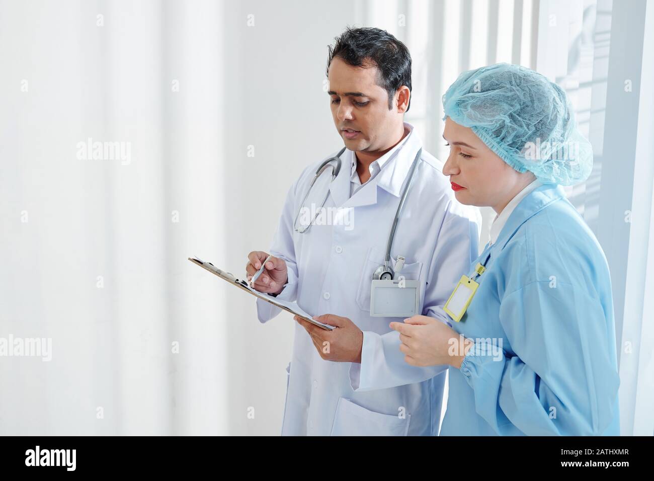 Surgeon and physician checking medical tests of patient before starting ...