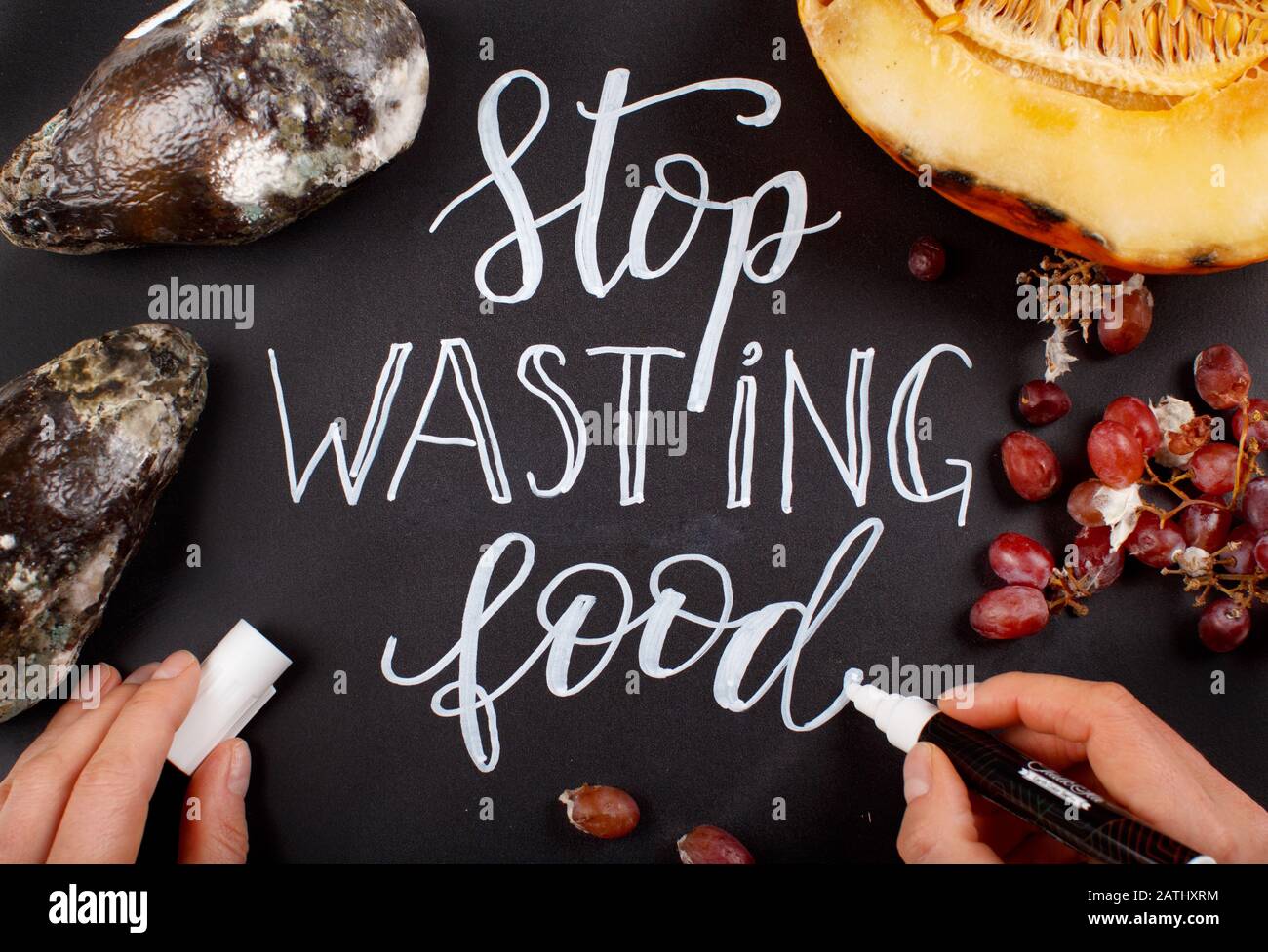 Woman writing on a chalkboard Stop wasting food lettering with rotten ...