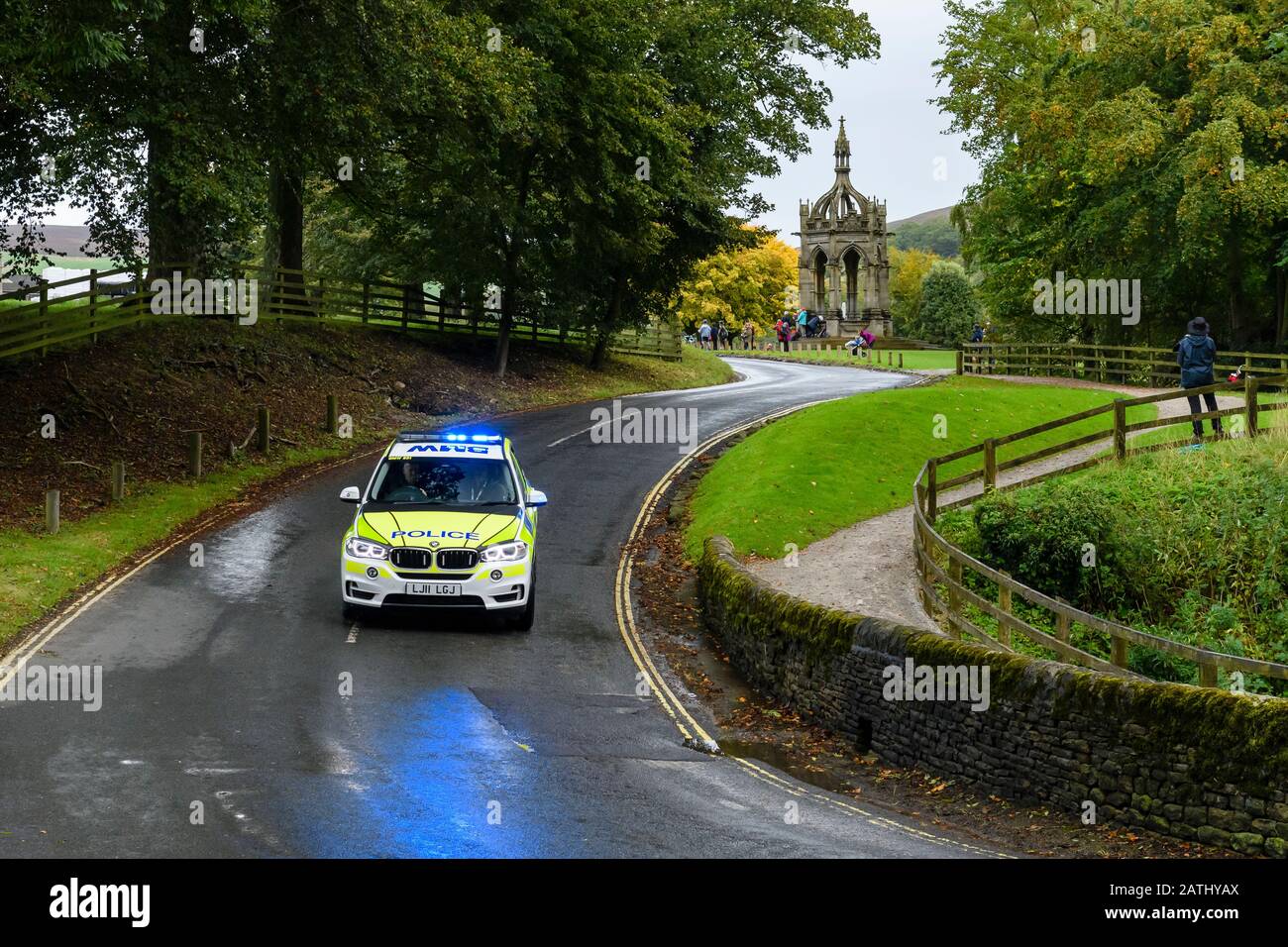 Police car driving & travelling on country lane with flashing blue ...