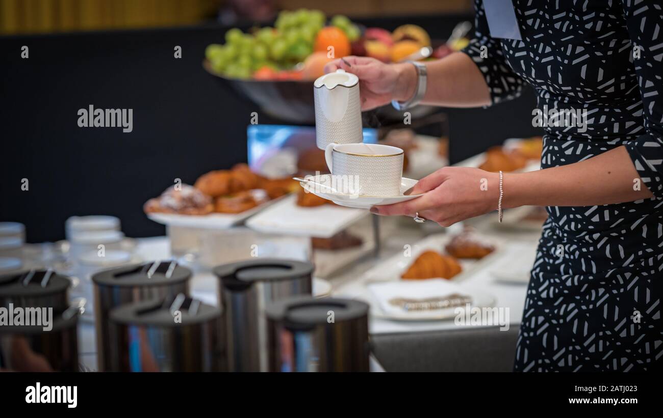 Lady Pouring Milk into her Coffee at a Buffet During a Business ...