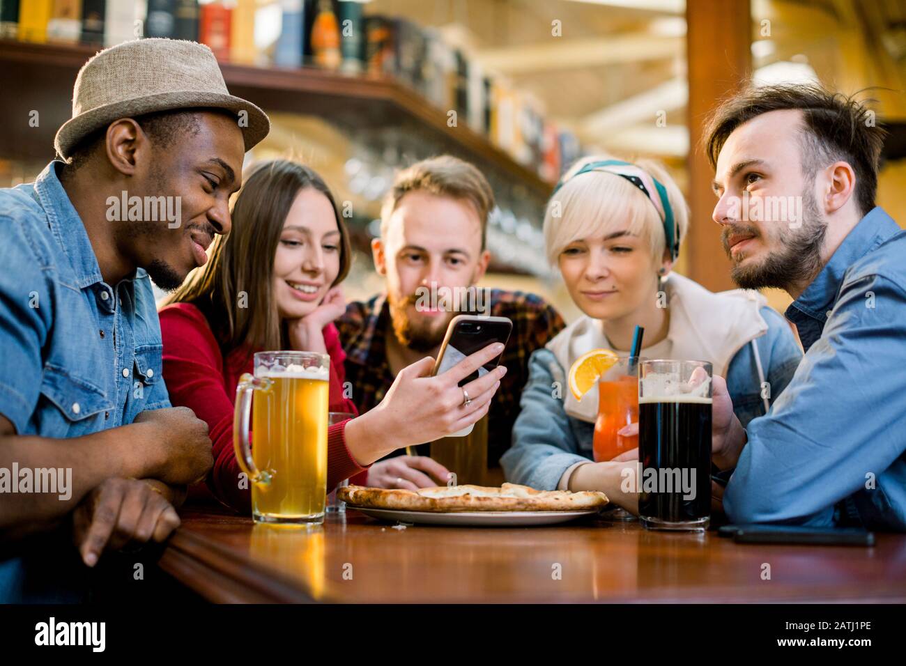 Young Friends Sharing Pizza In A Indoor Cafe Multiracial Happy