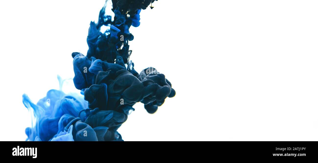 Mix of black and classic blue ink in water on an isolated white ...