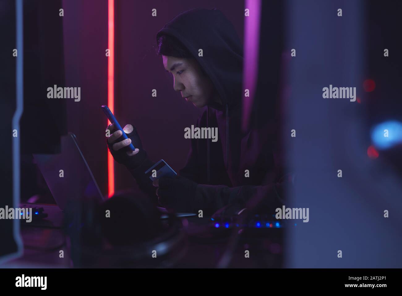 Side view portrait of Asian man wearing black and using computer while ...