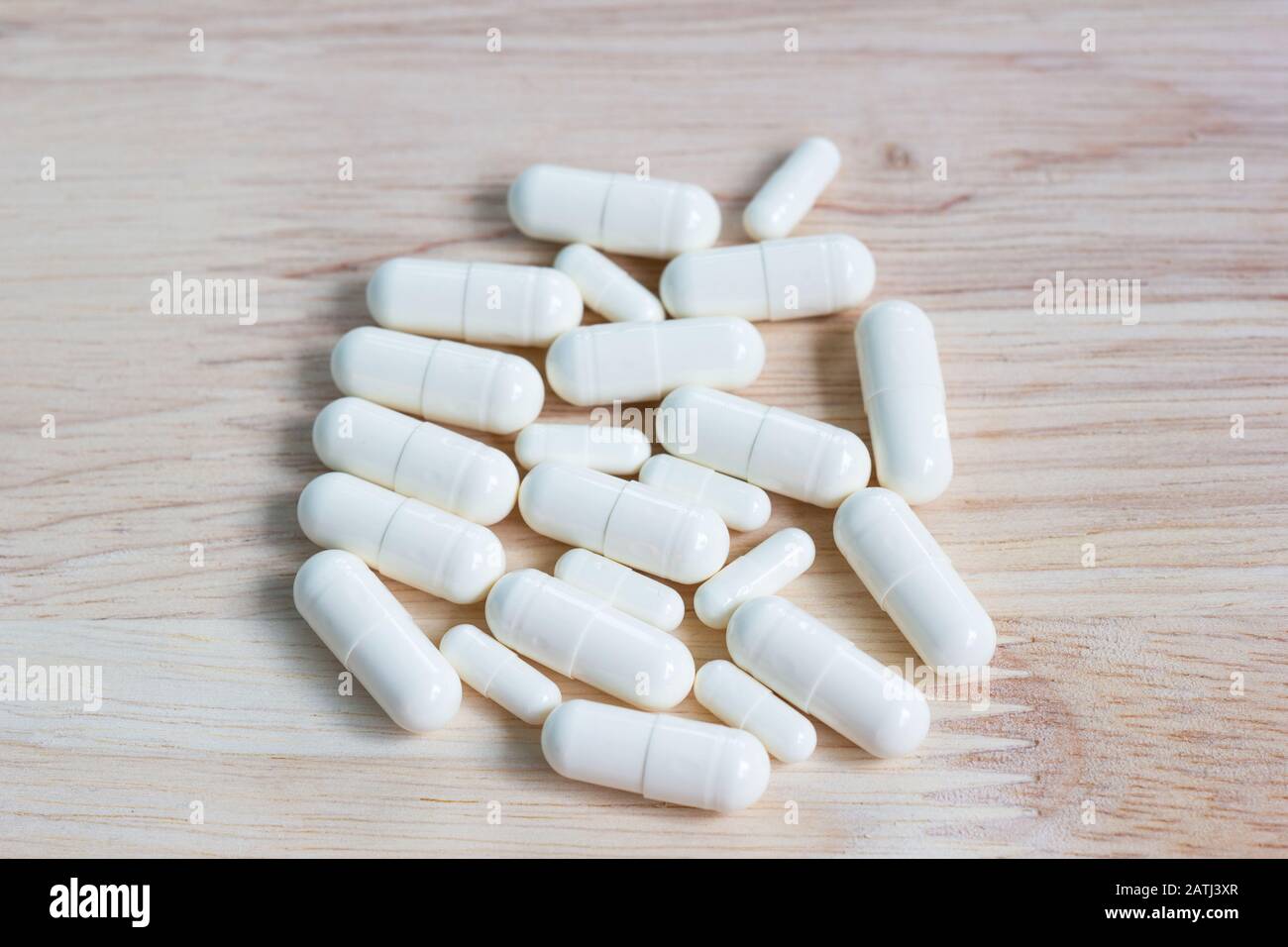 the white many capsules on wood table Stock Photo - Alamy