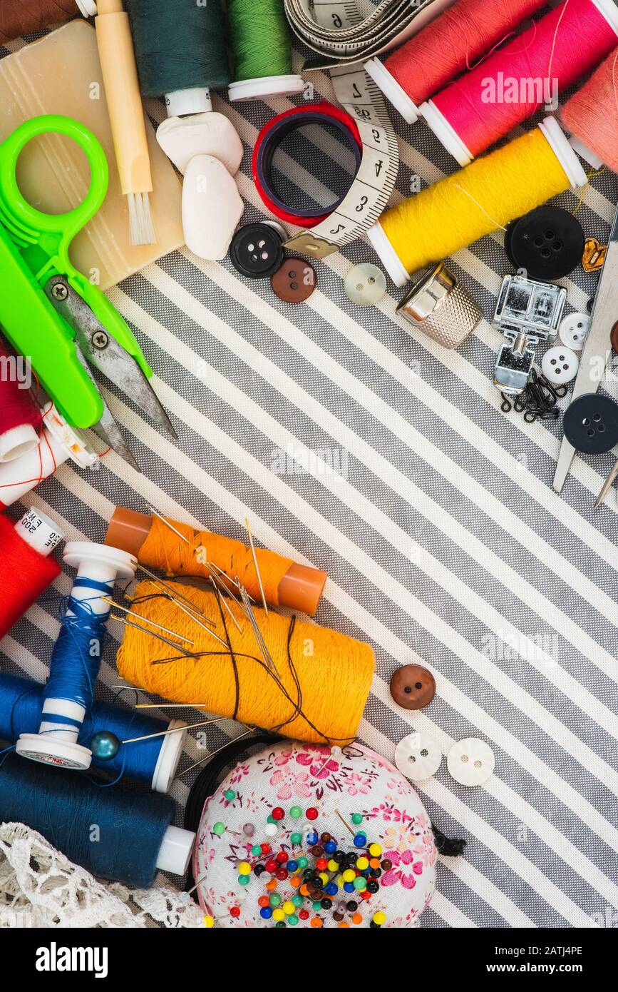 Sewing tools on striped background top view Stock Photo - Alamy
