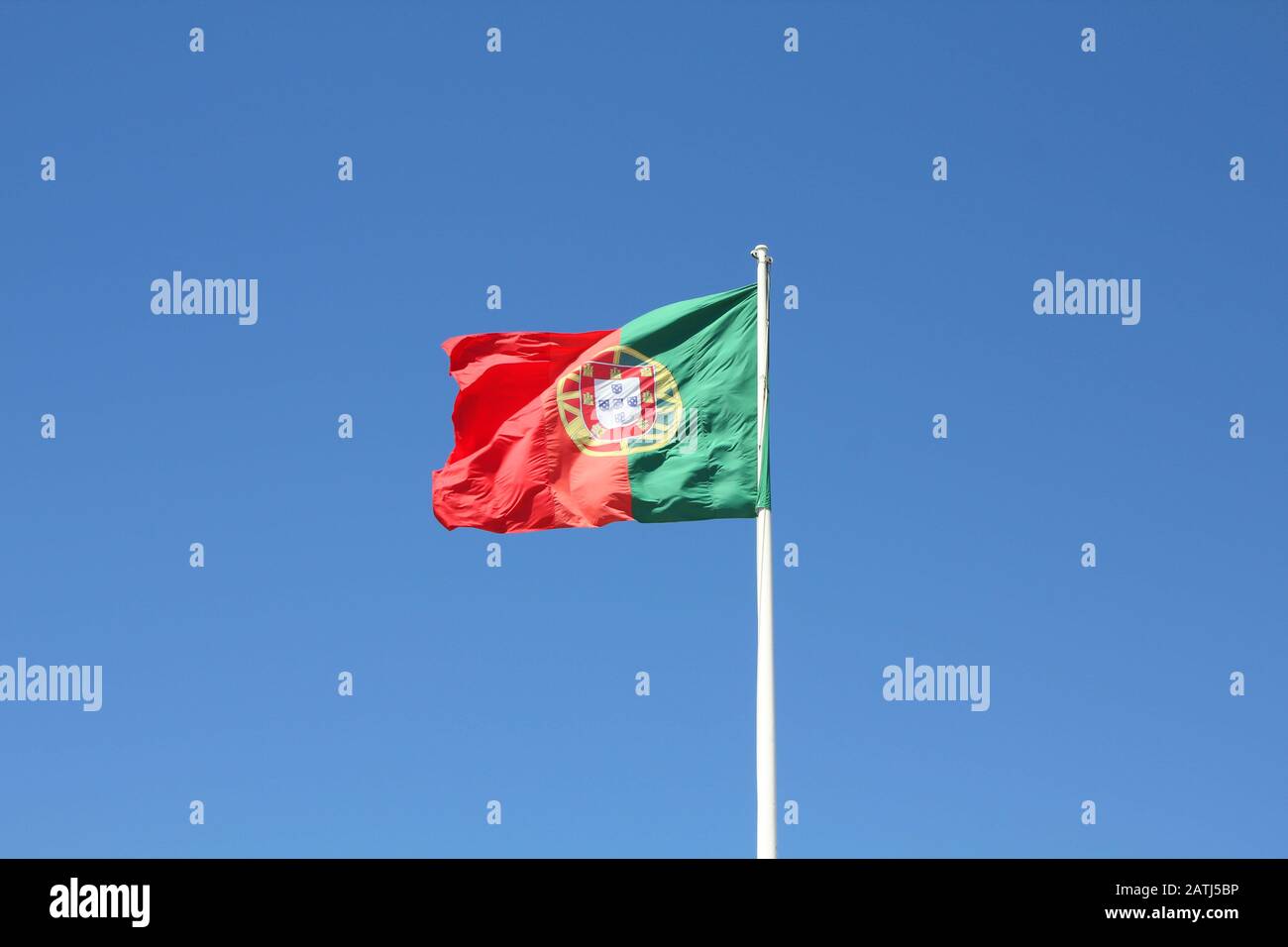 Portugal flag waving in the wind over blue sky Stock Photo - Alamy
