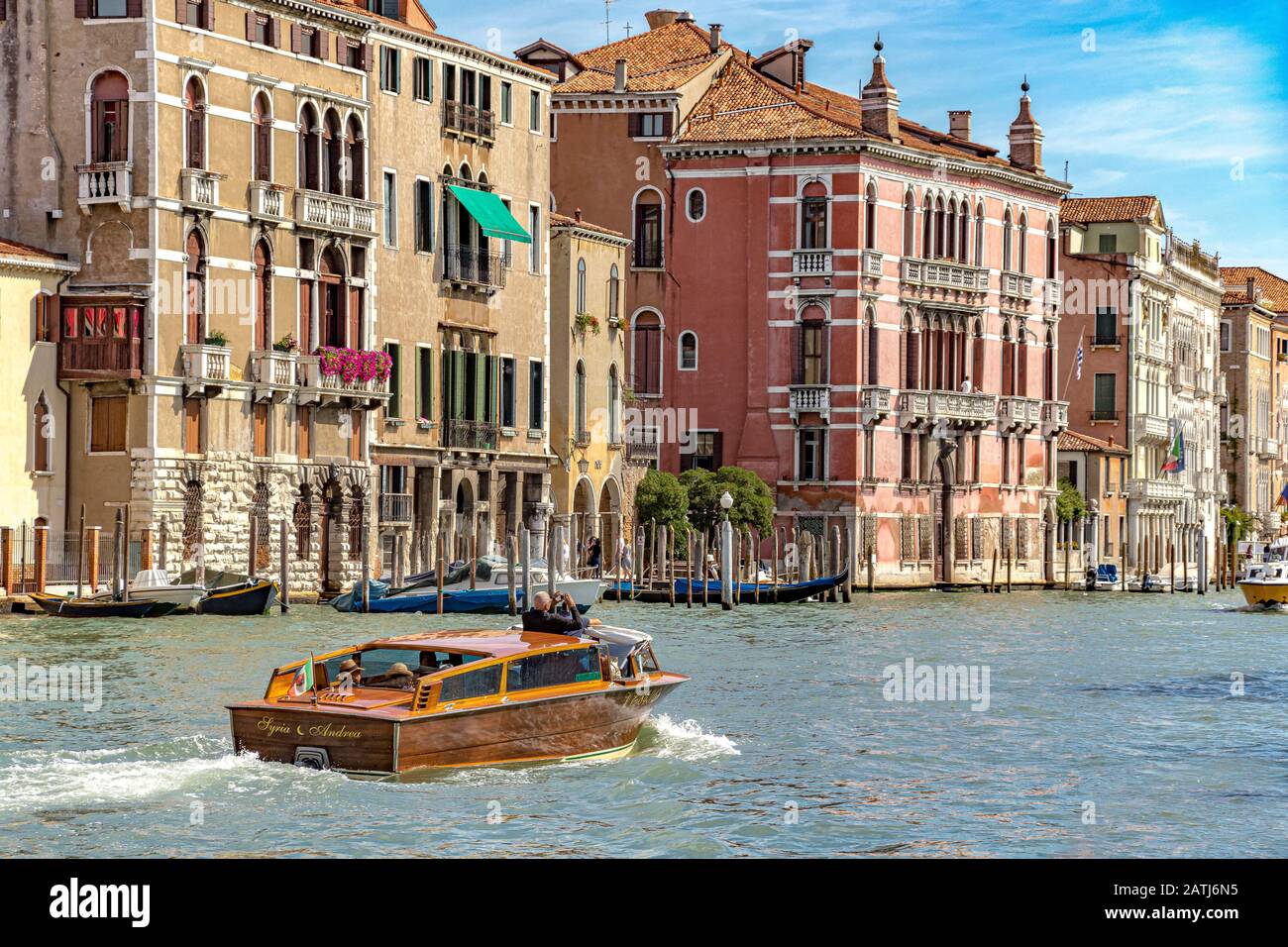 A water taxi with passengers makes it's way along the Grand Canal in ...