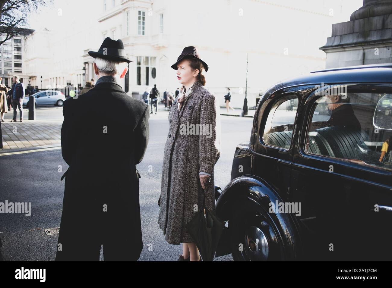 Man and woman in 1940's dress. They are extras waiting for their scene ...