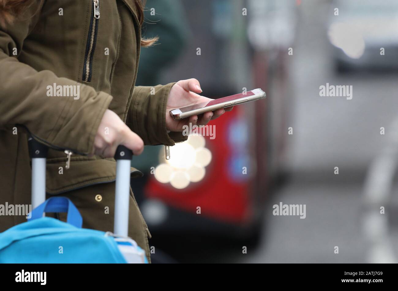 A person using their phone at a pedestrian crossing. Pedestrians who ...