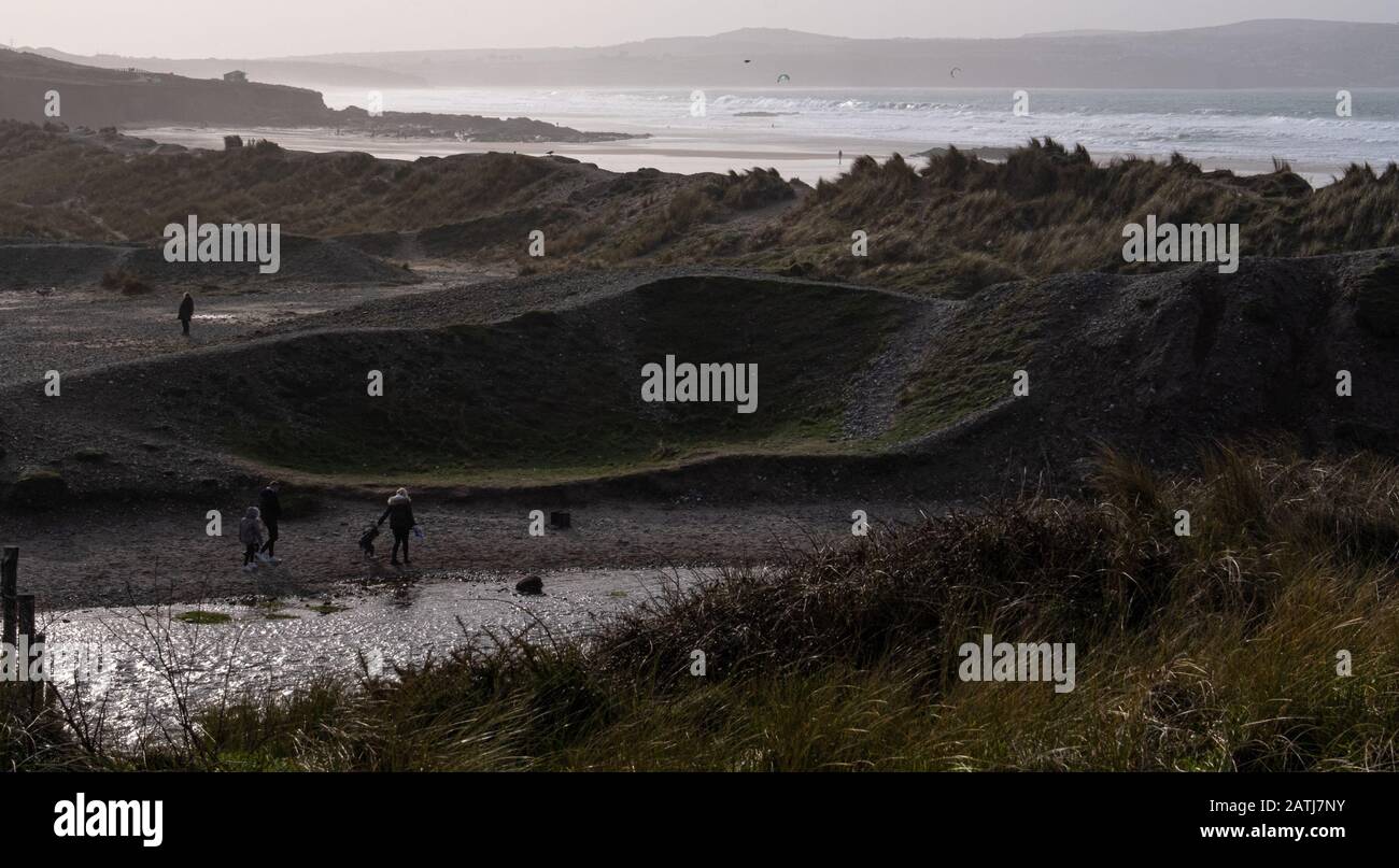 Weird sand dune landscape with water and sea in dark subdued colours ...