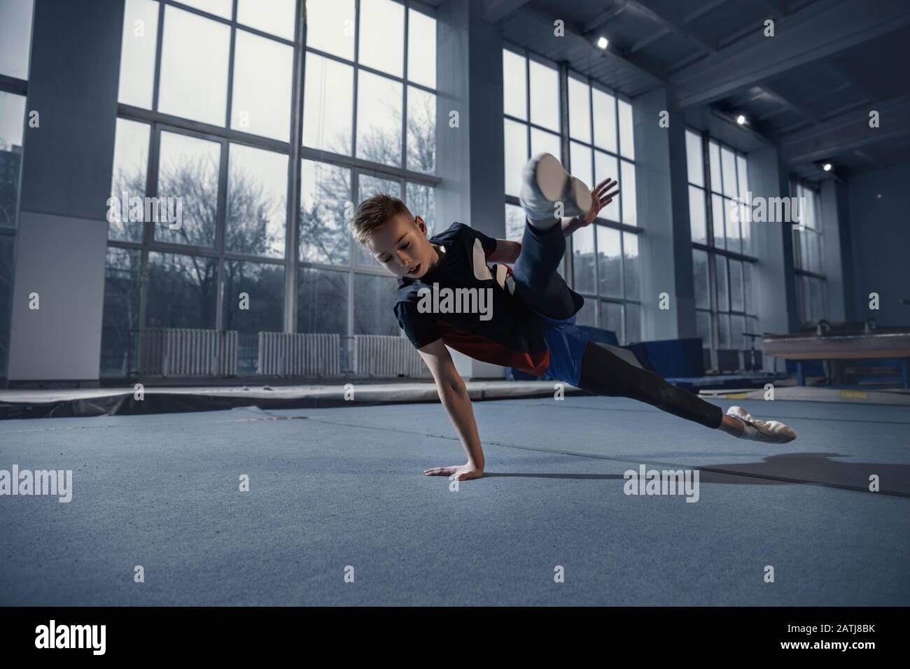 Little male gymnast training in gym, flexible and active. Caucasian fit ...