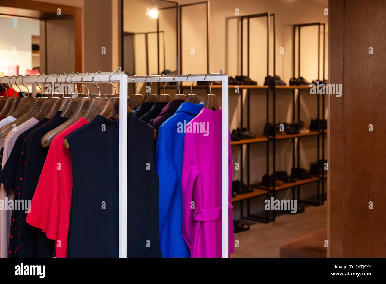 Closeup colorful male, female clothes in boutique hanging on hangers ...
