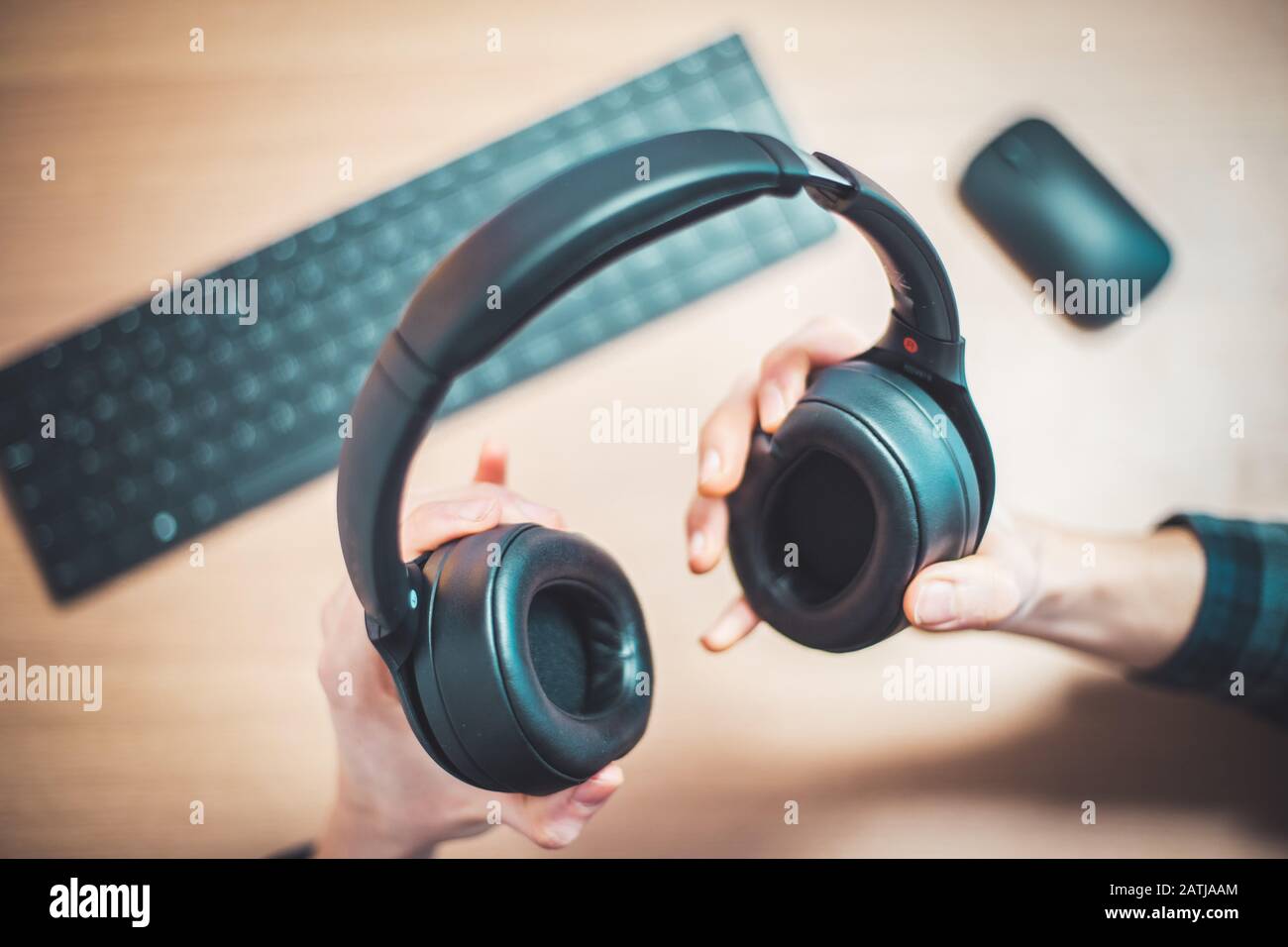 Male hands are holding black wireless headphones, workspace Stock Photo ...