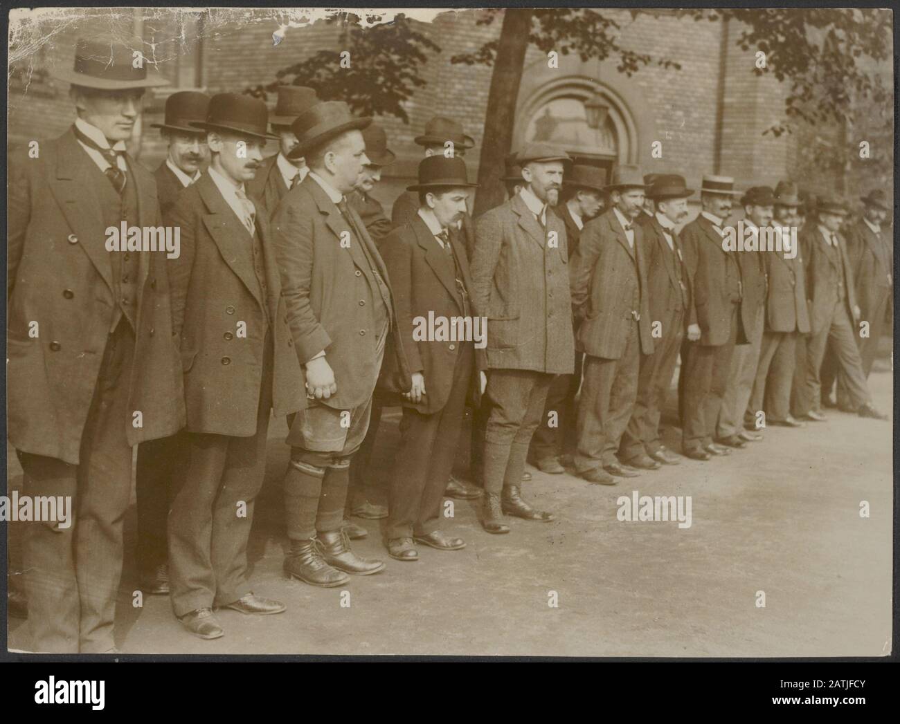 Description: Group of men standing next to each other in two long lines ...