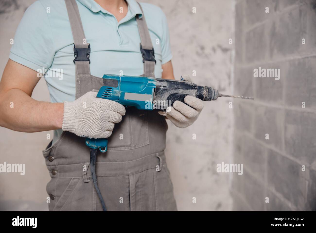 Builder man with pneumatic hammer drill perforator with diamond crown ...