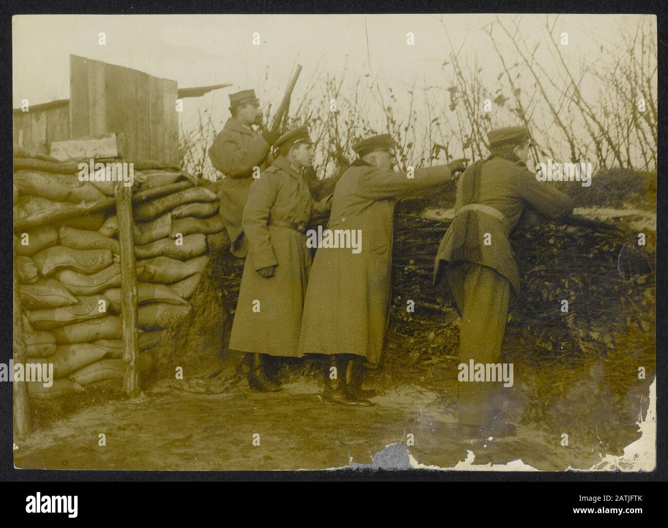 Description: Armed German soldiers behind a parapet studying an object ...