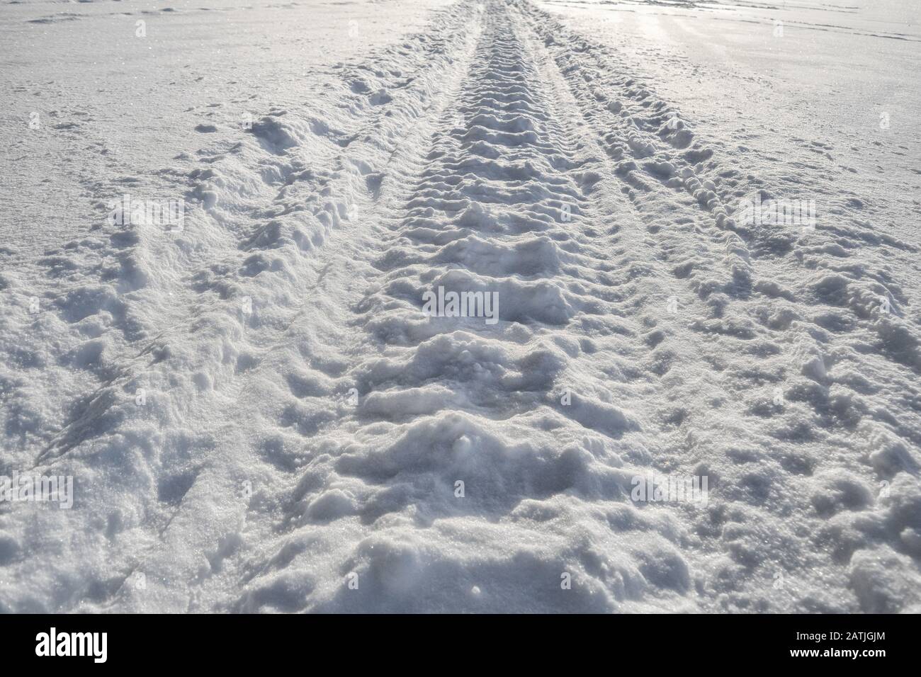 Snowmobile track on frozen river. Footprints in the snow on a ...