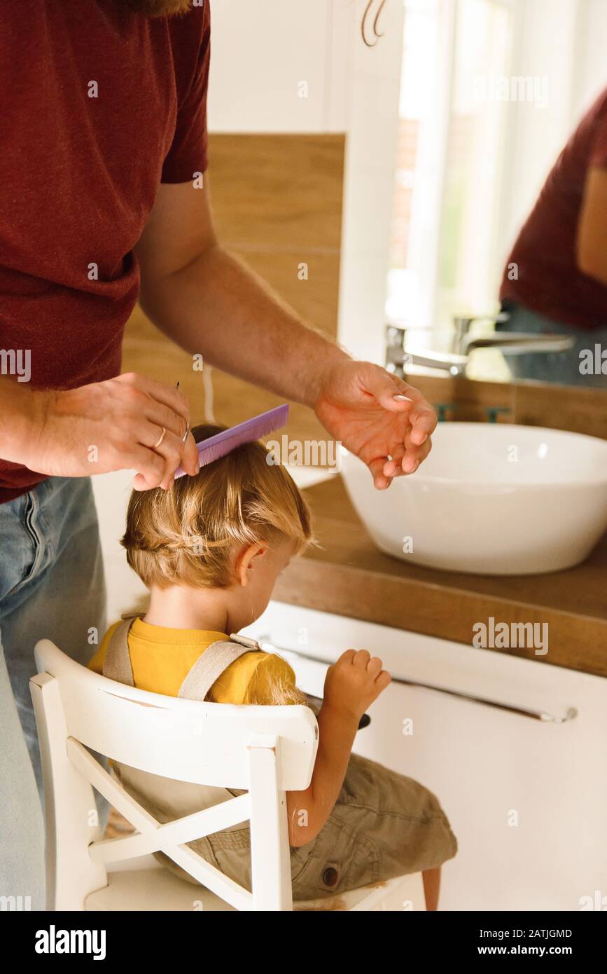 Dad cutting hair to little son Stock Photo - Alamy