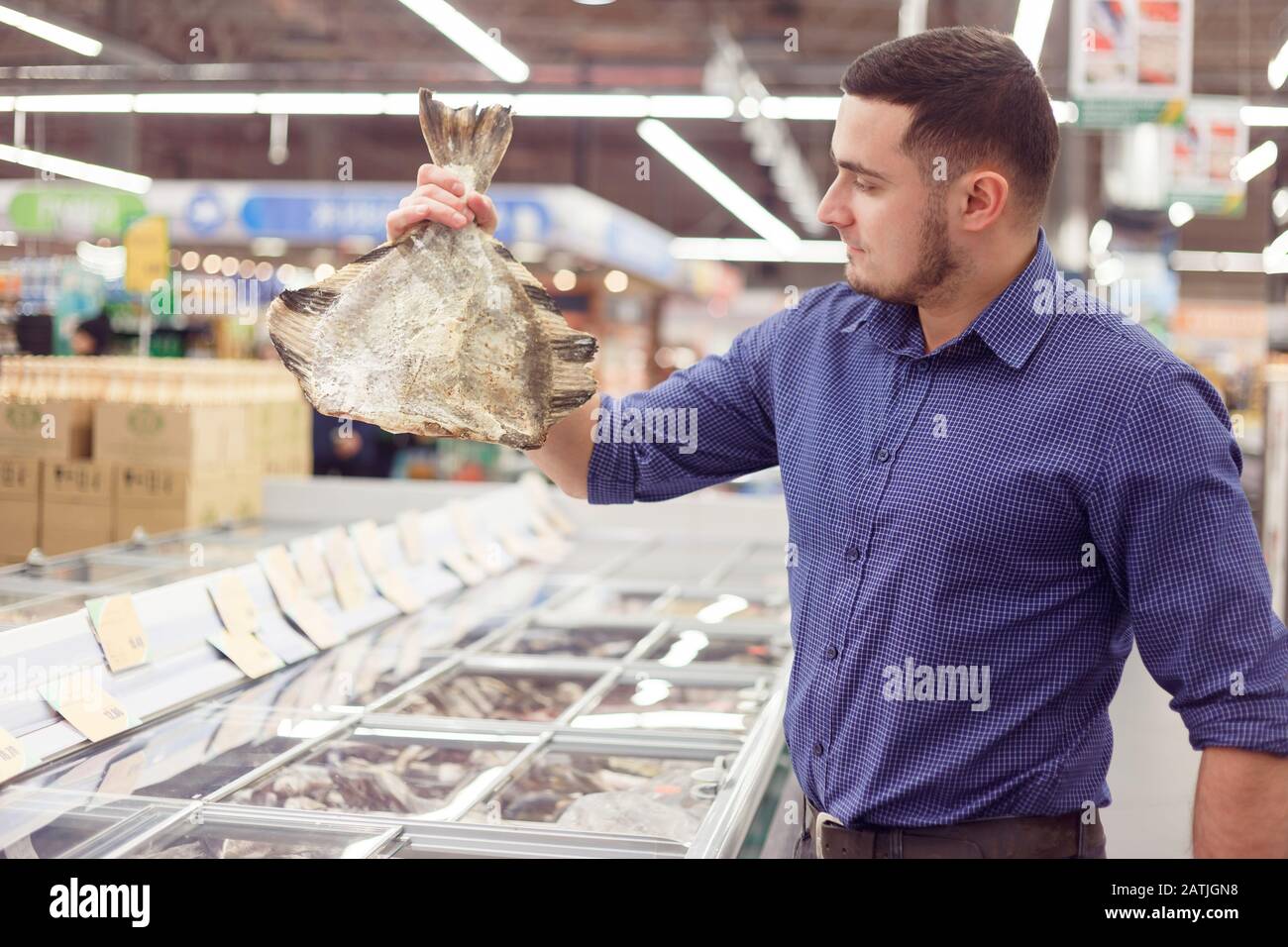 Man at the grocery store chooses frozen flounder fish Stock Photo - Alamy
