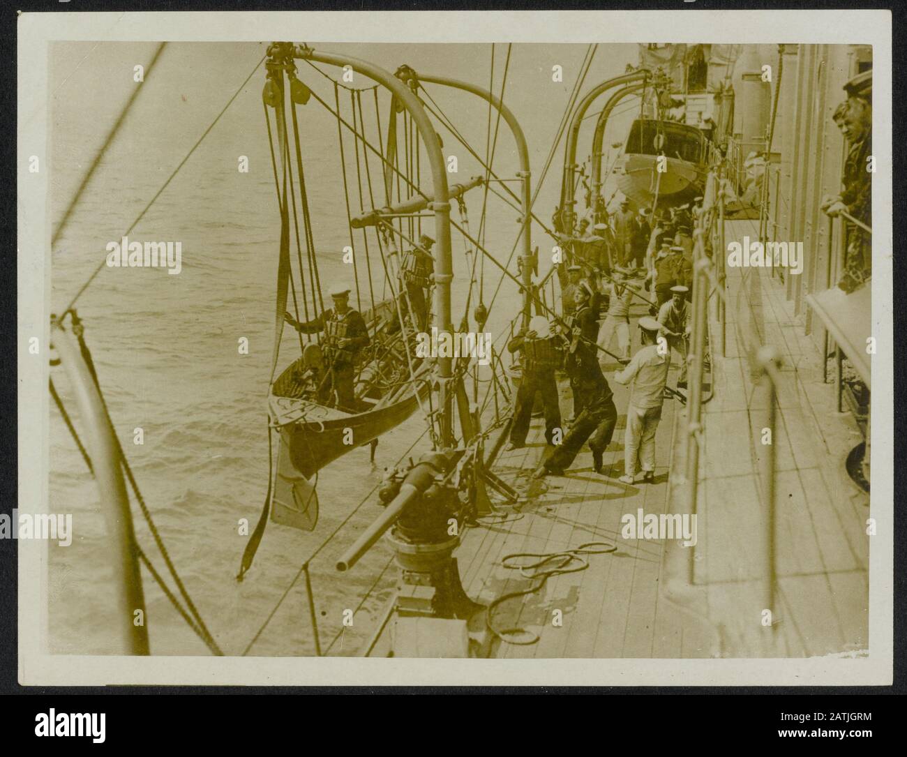 With the British navy in war time Description: Hoisting boat into H.M.S ...