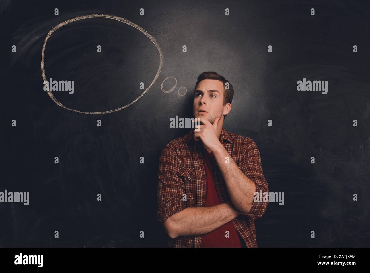 Portrait of minded young man having an idea Stock Photo - Alamy