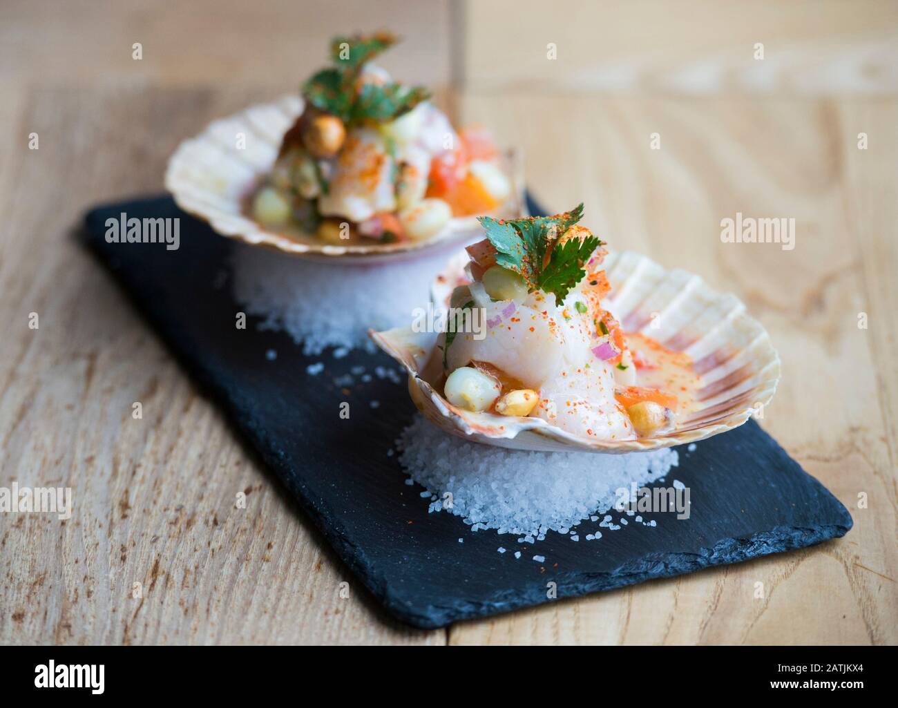 Fresh Scallops Ceviche served in a shell are shown on a table at a ...